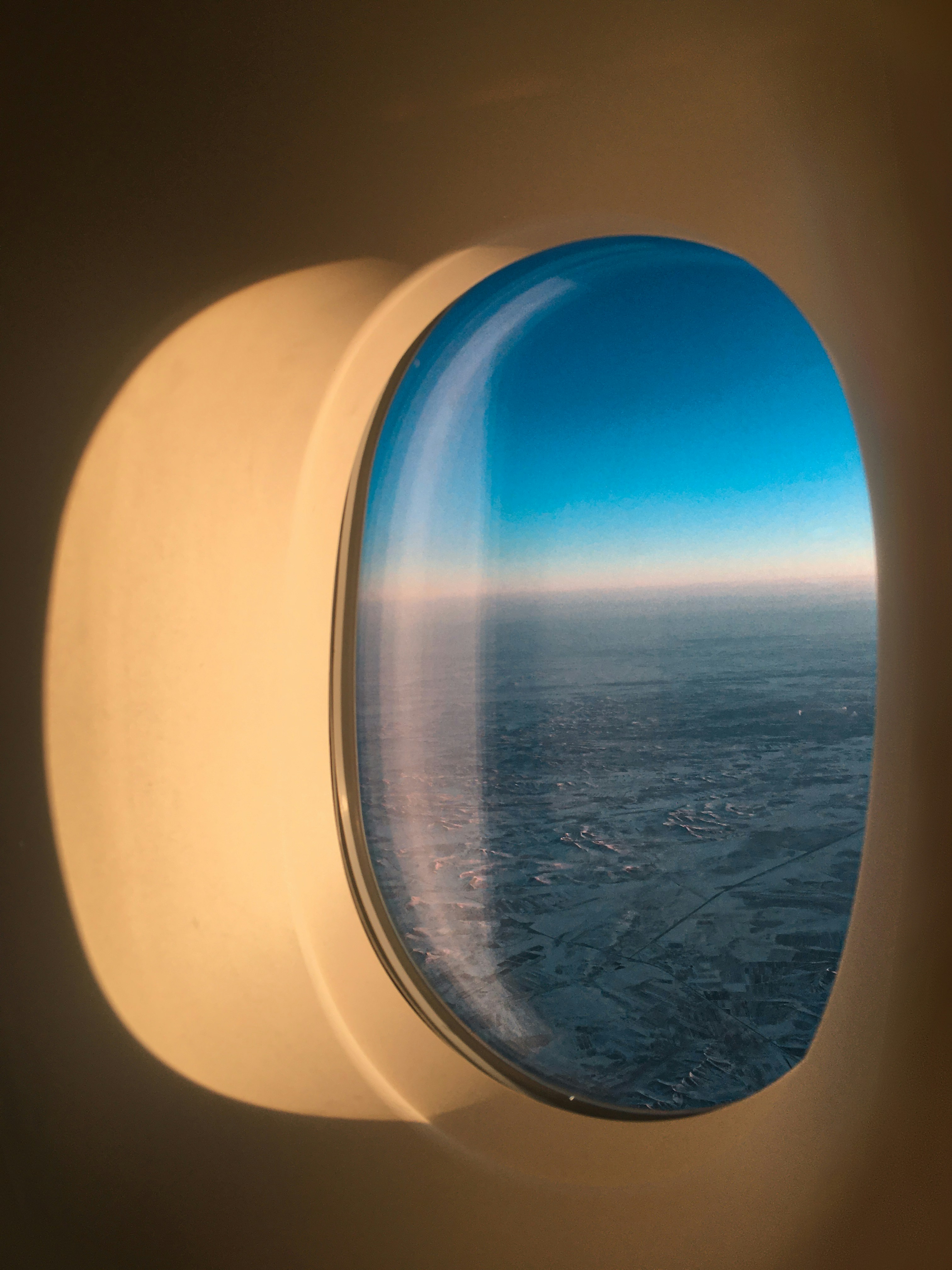 Horizon through the Oval Window: Sunset over a Frosted Expanse