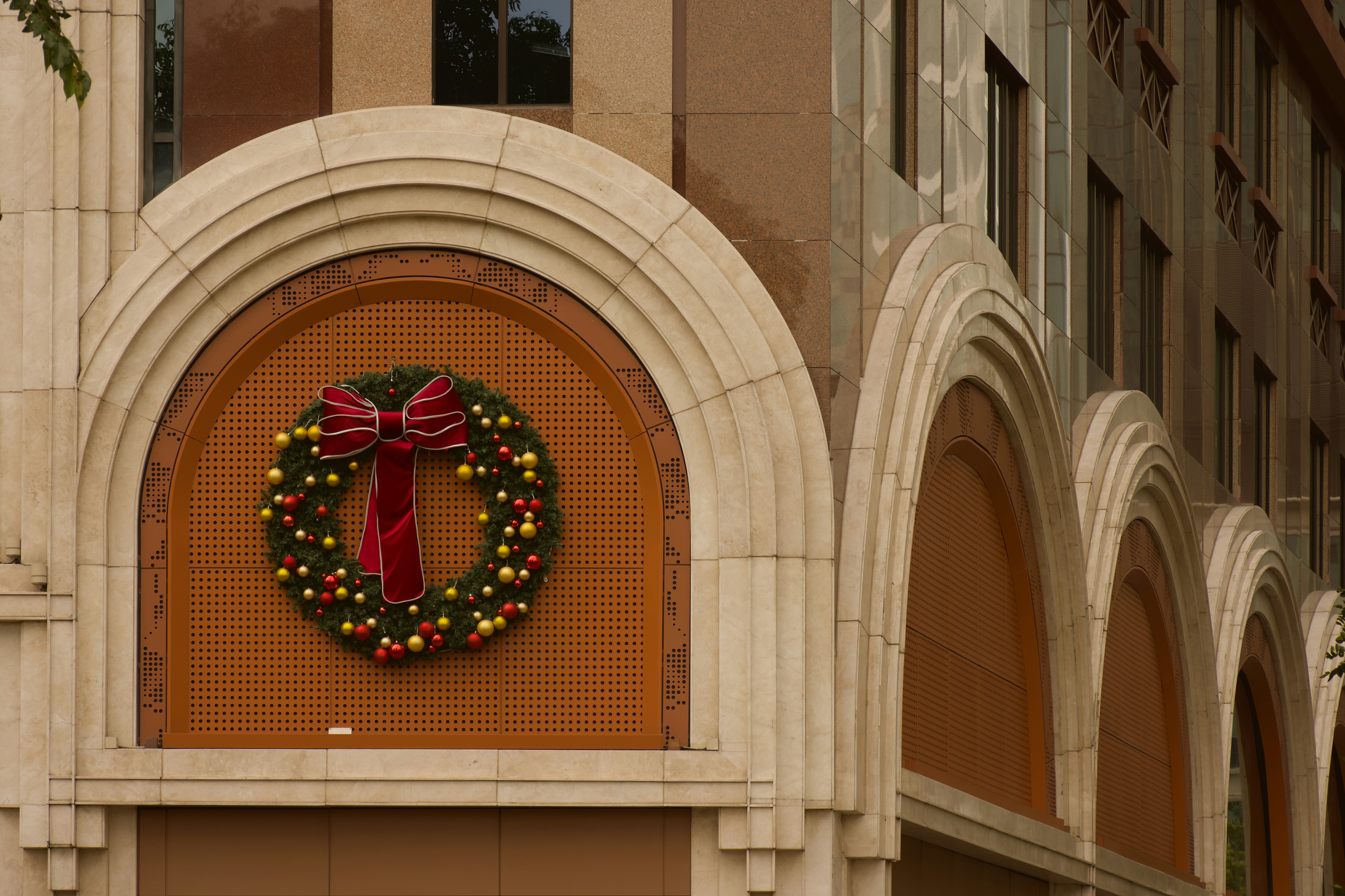 Wreath Framed by Stone Arches: Christmas Emblem on a Civic Façade