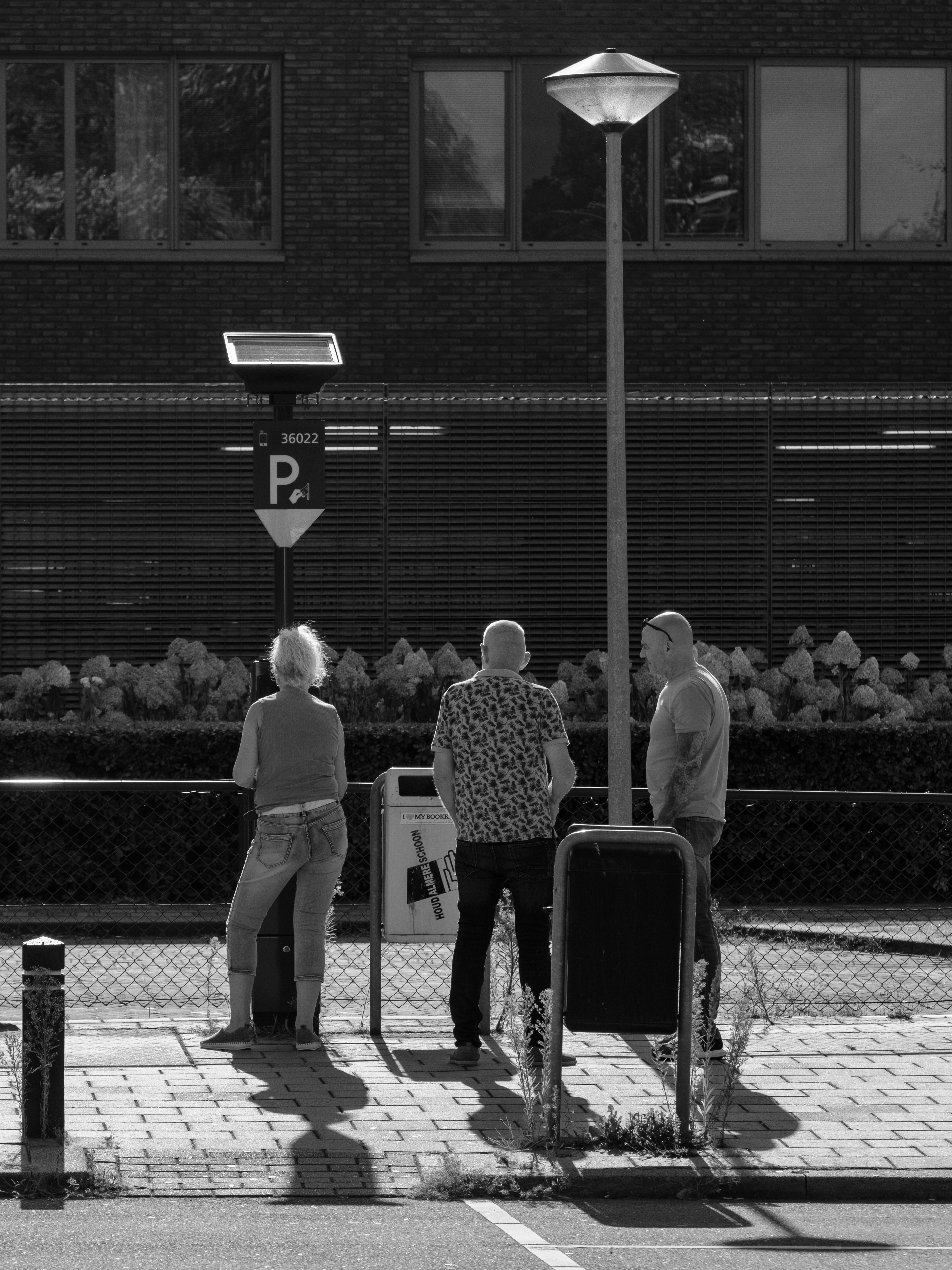 Monochrome Confluence: Three Figures at a Quiet Street Corner