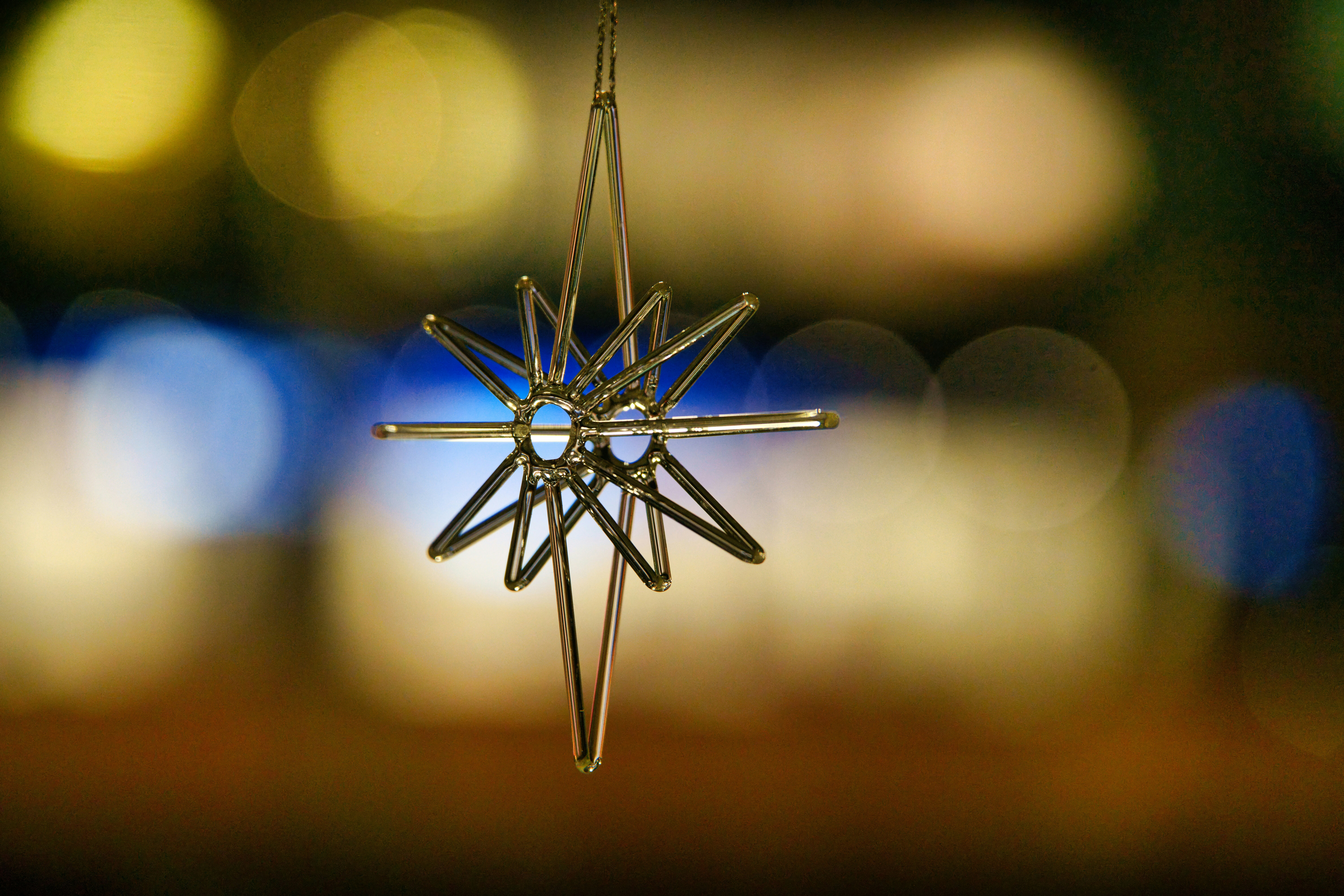 Hanging Star: a metal snowflake glistens against a bokeh-night backdrop