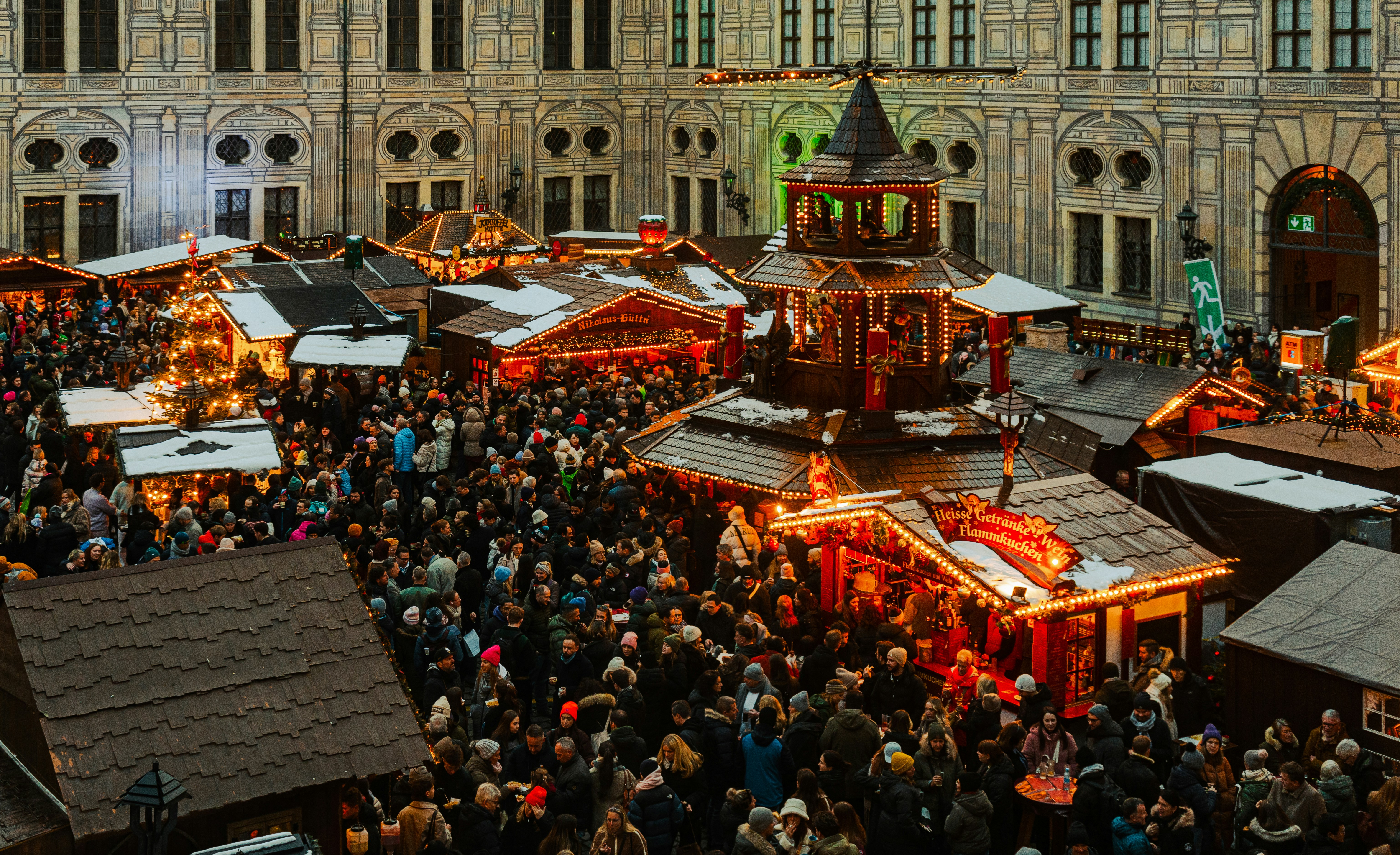 A crowd of people standing around a christmas market photo – Free ...
