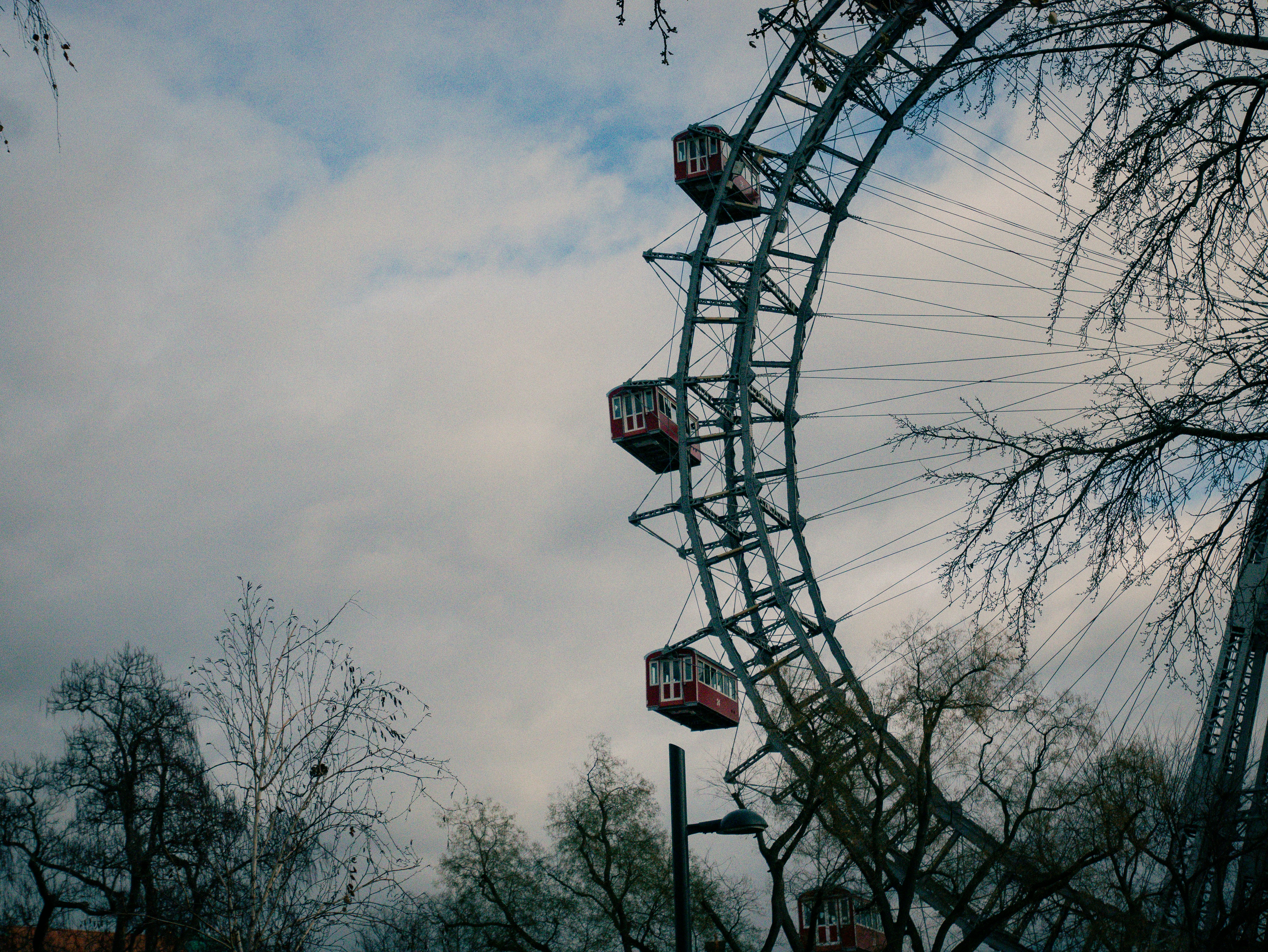 Crimson Cabins Crown the Ferris Wheel Beneath a Moody Sky