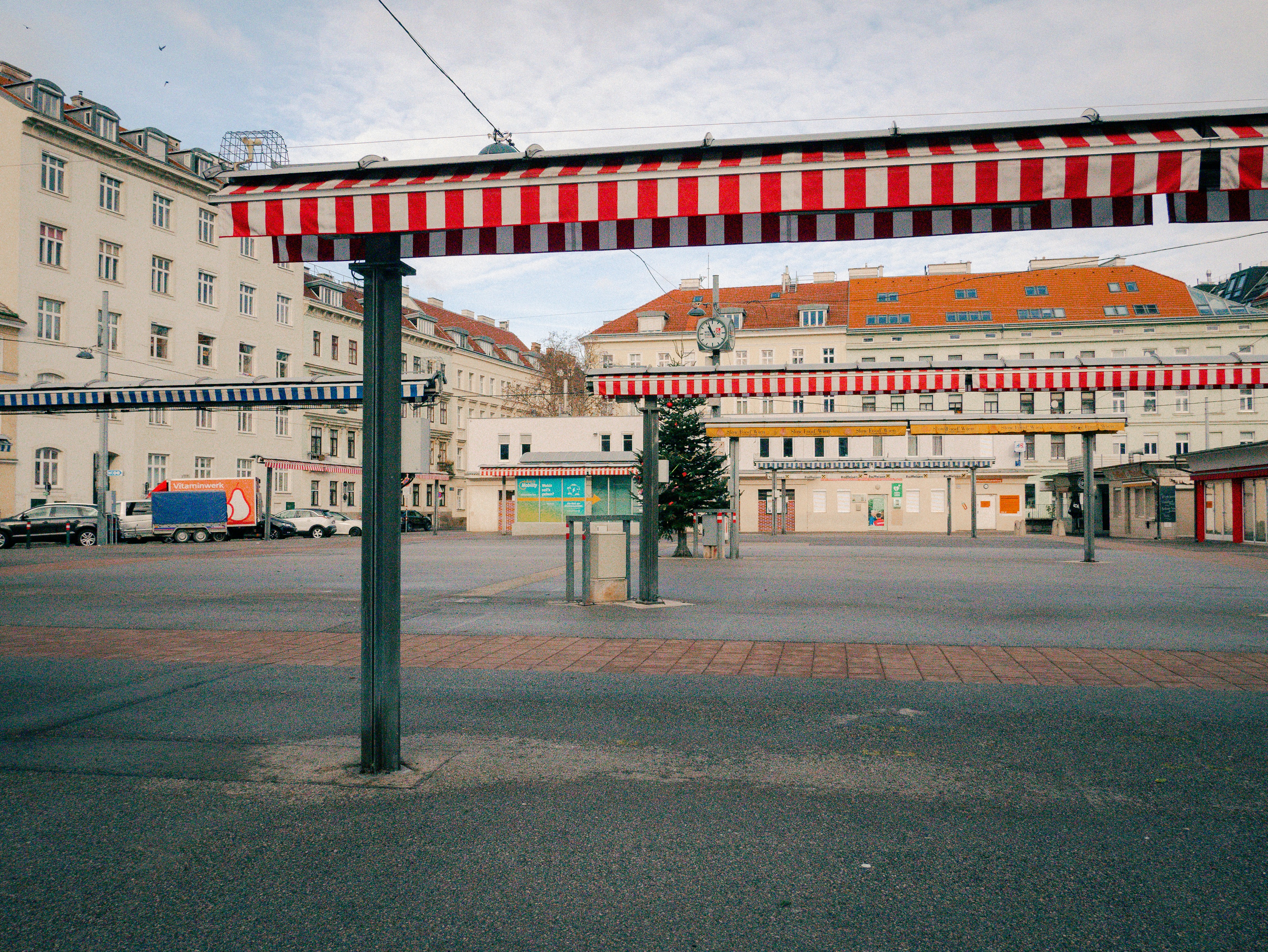 Red-and-White Canopies Crown a Placid European Plaza