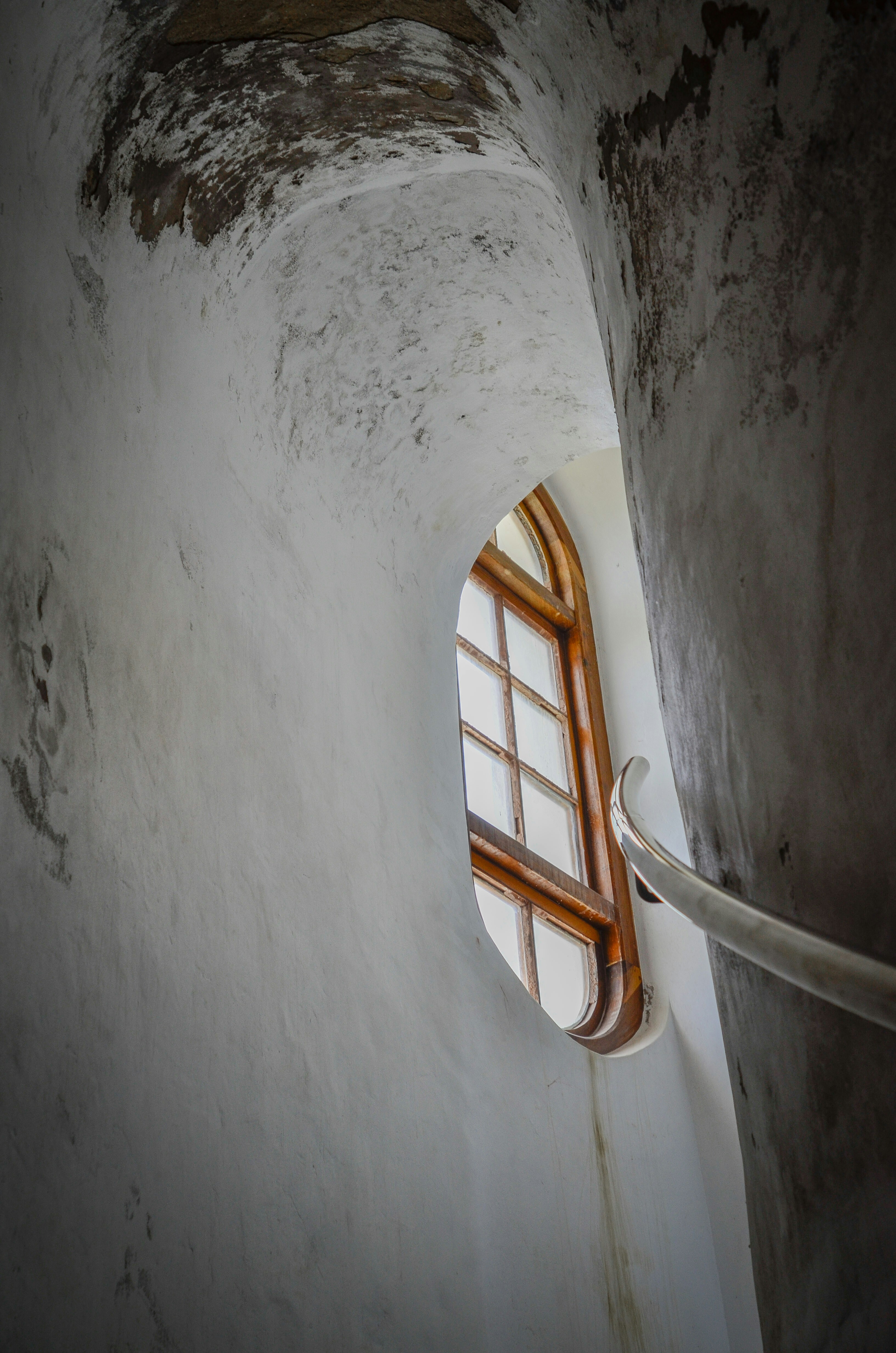 Arc of Light: An Arch Window Framing a Curved Stairwell