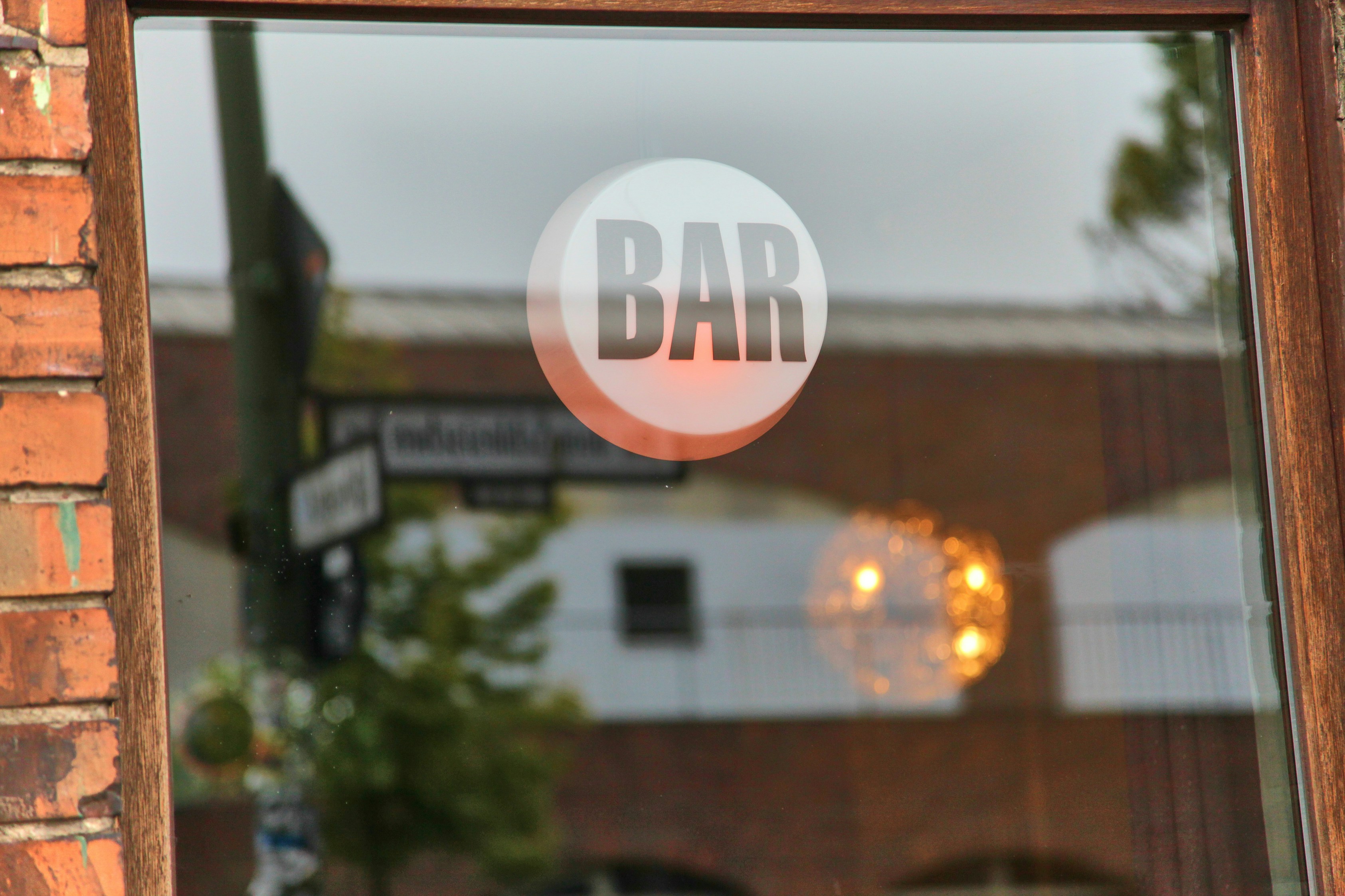 Circular Bar Sign Reflected in a Glass Window