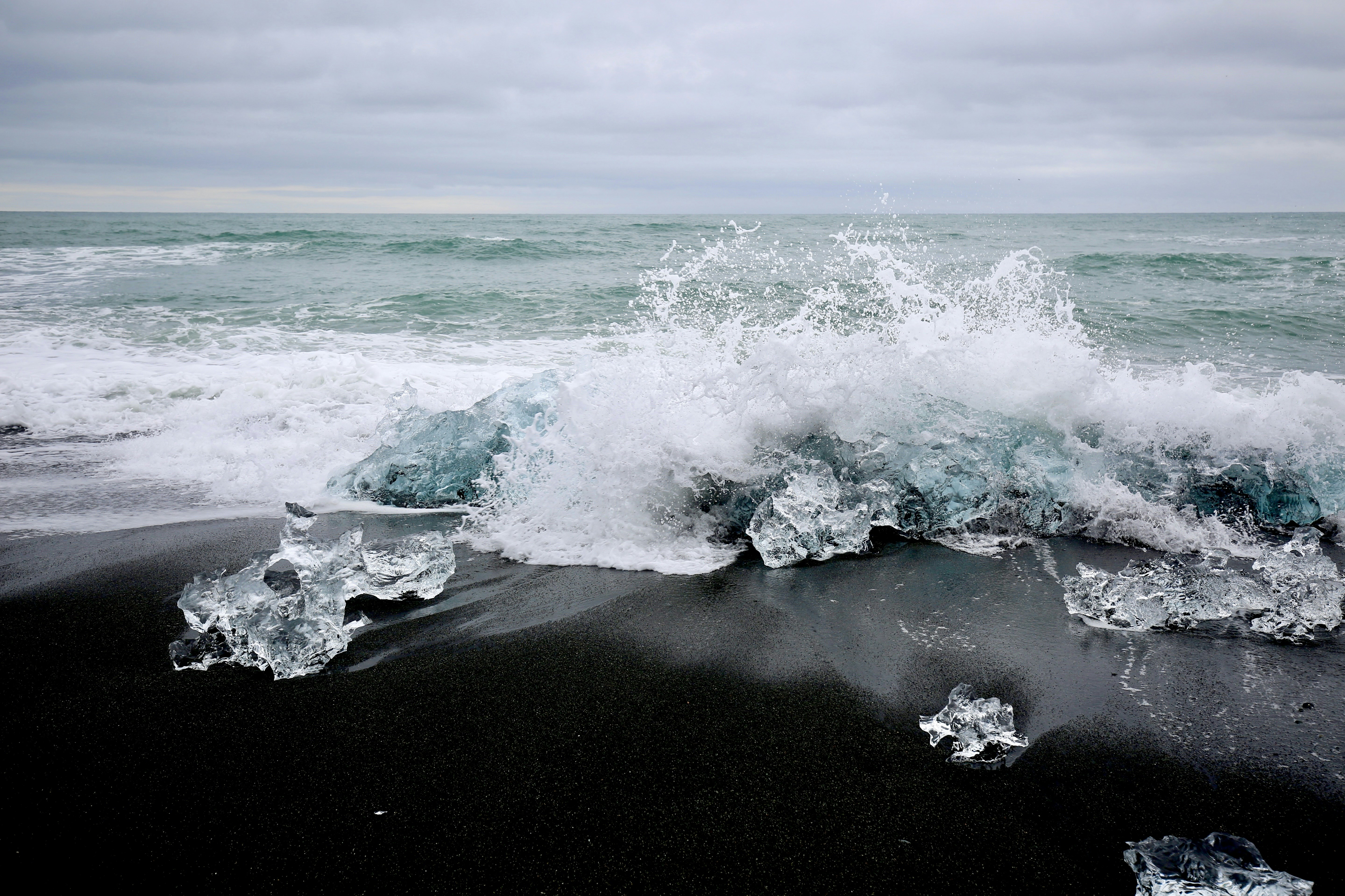 A wave crashes on a black sand beach photo – Free Sea Image on Unsplash
