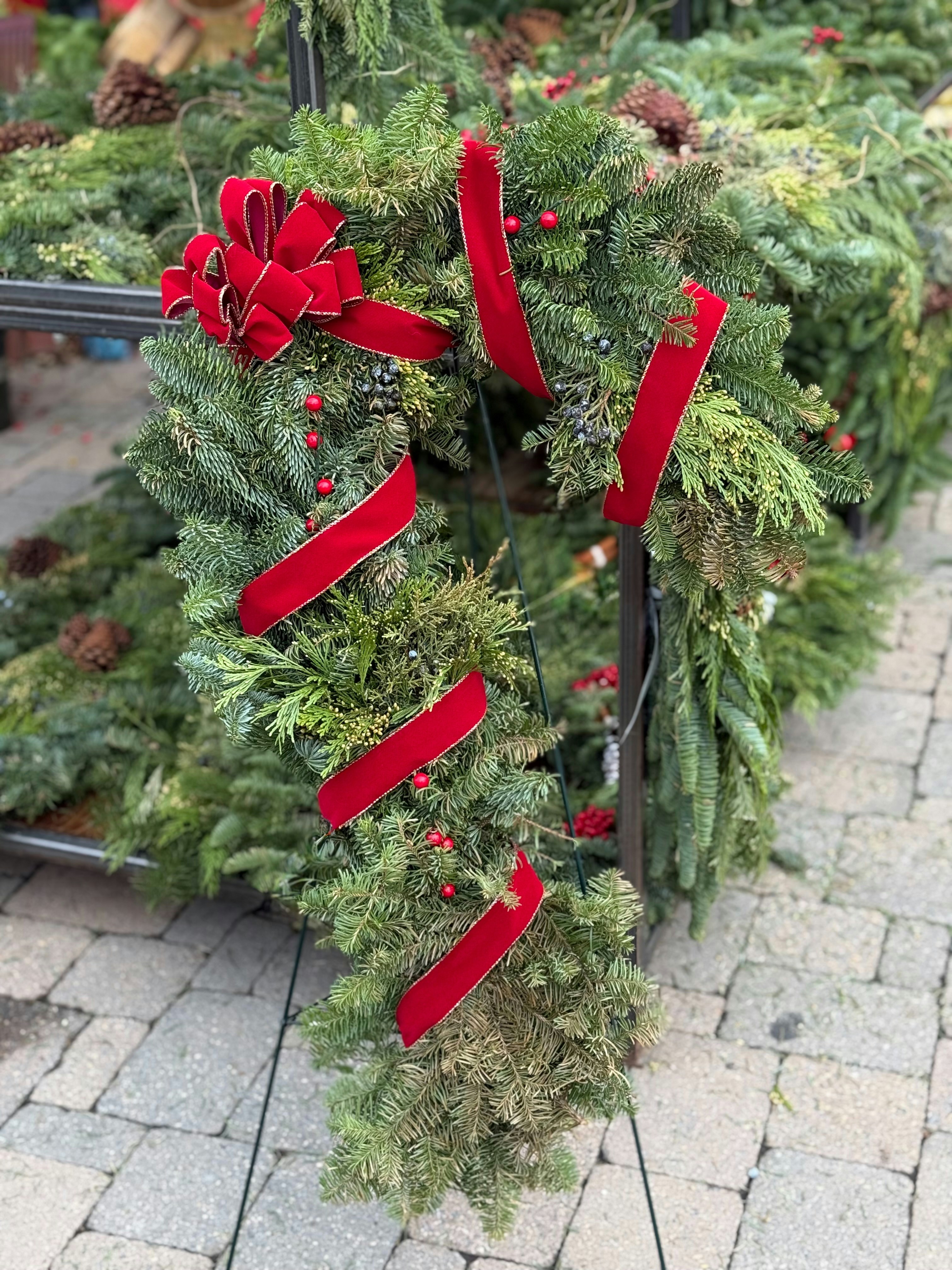 Festive wreath on display: deep greens and crimson ribbons crown a metal frame