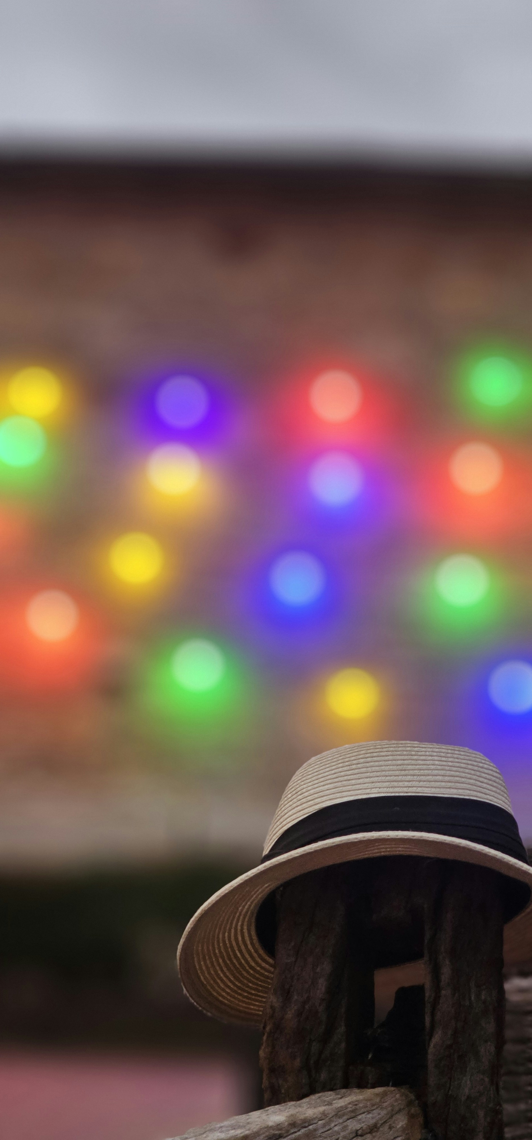 A hat resting on weathered wood with a glow of colorful orbs in the background