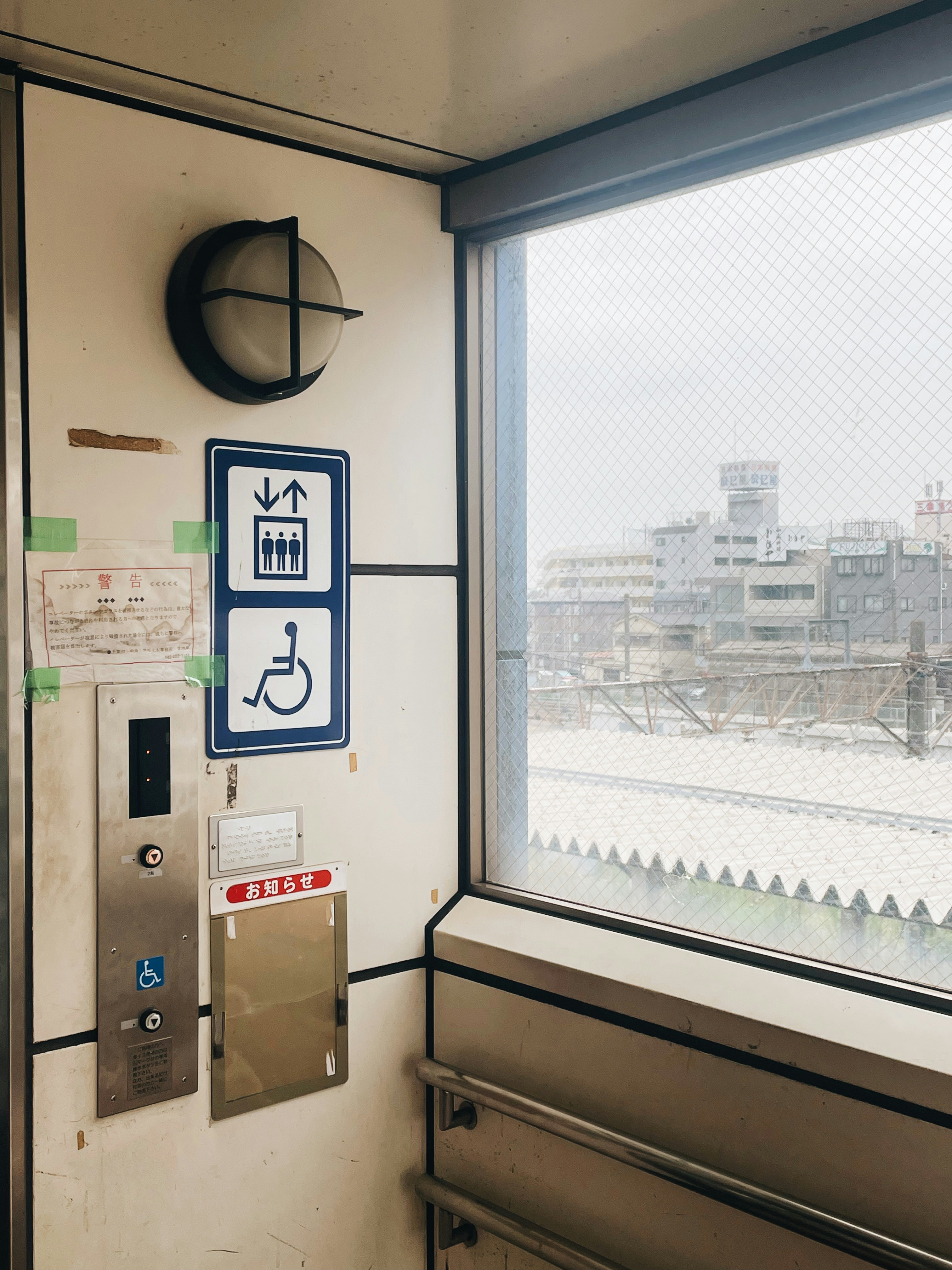 Accessibility Signage Framed by a City-View Elevator Hallway