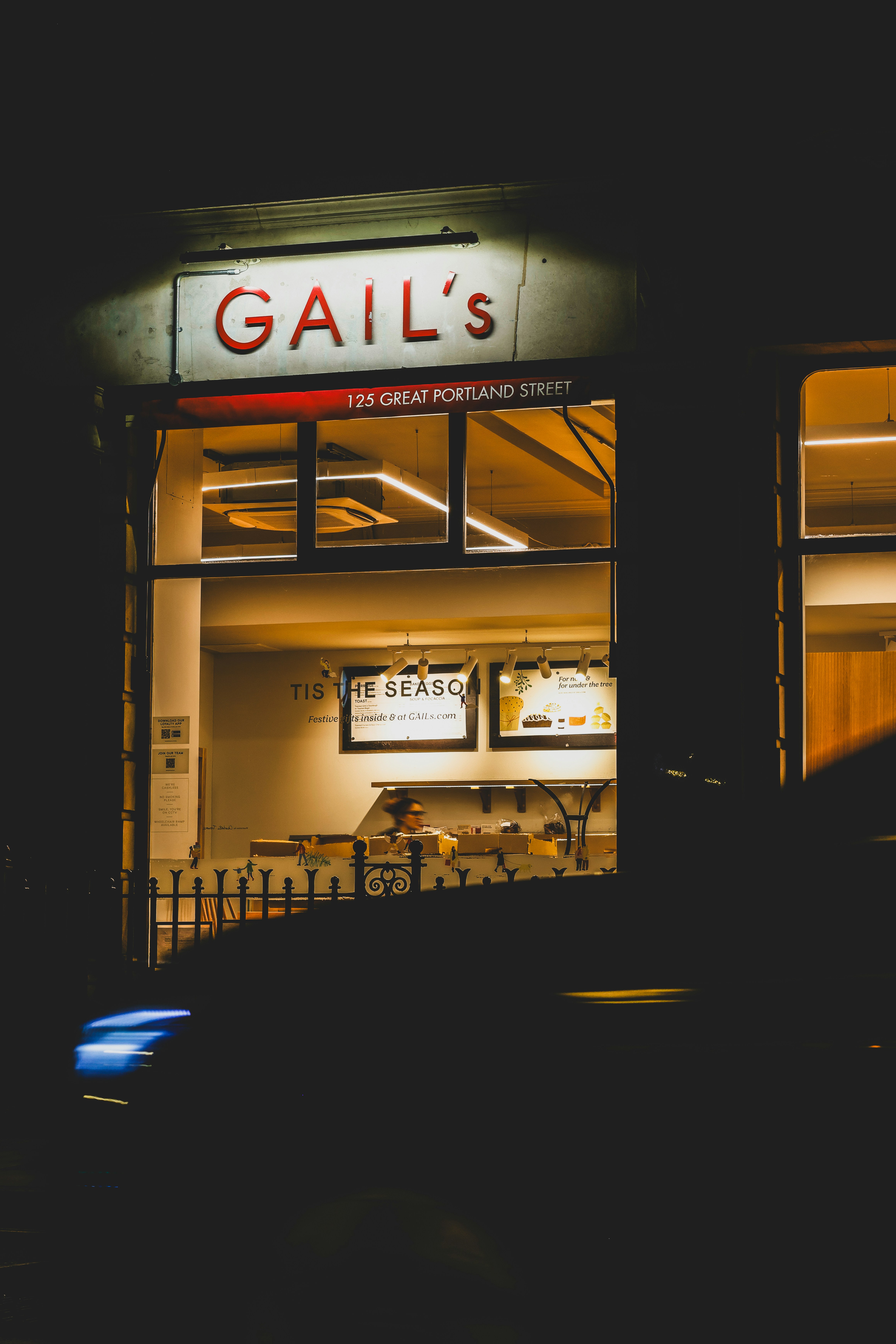 A store front at night with cars parked outside photo – Free Great ...