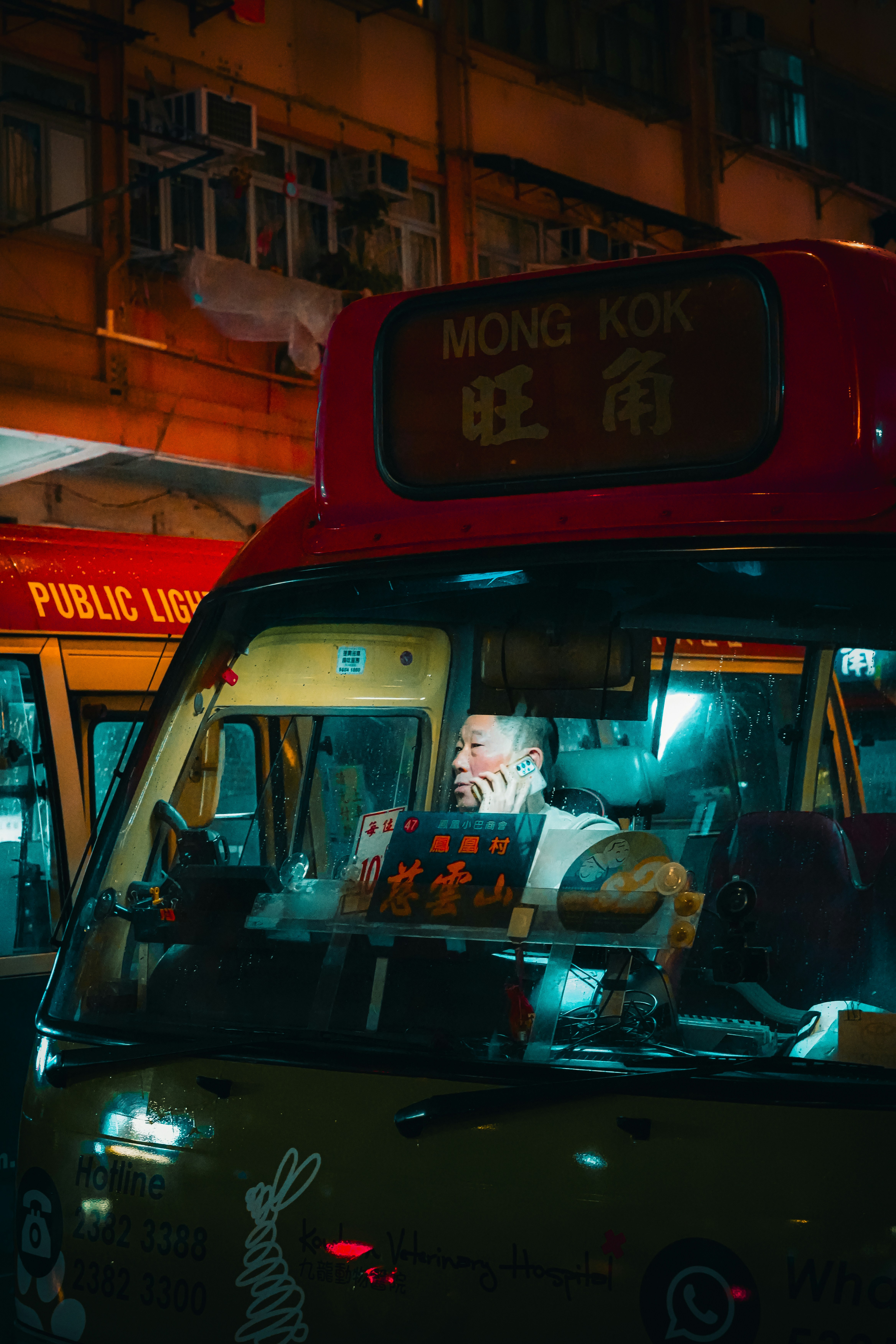 A red bus driving down a street at night photo – Free Human Image on ...