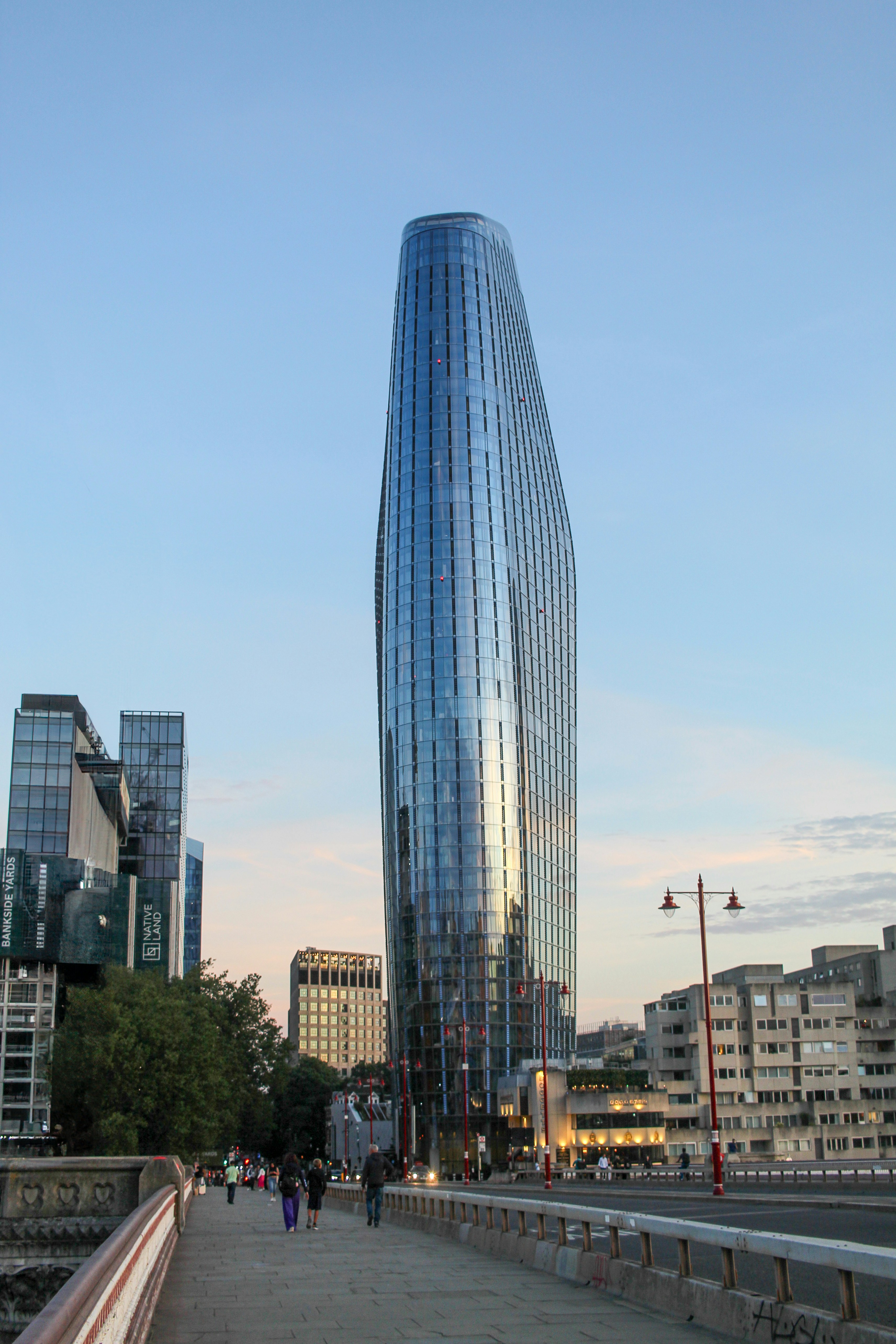 A very tall glass building towering over a city photo – Free Building ...