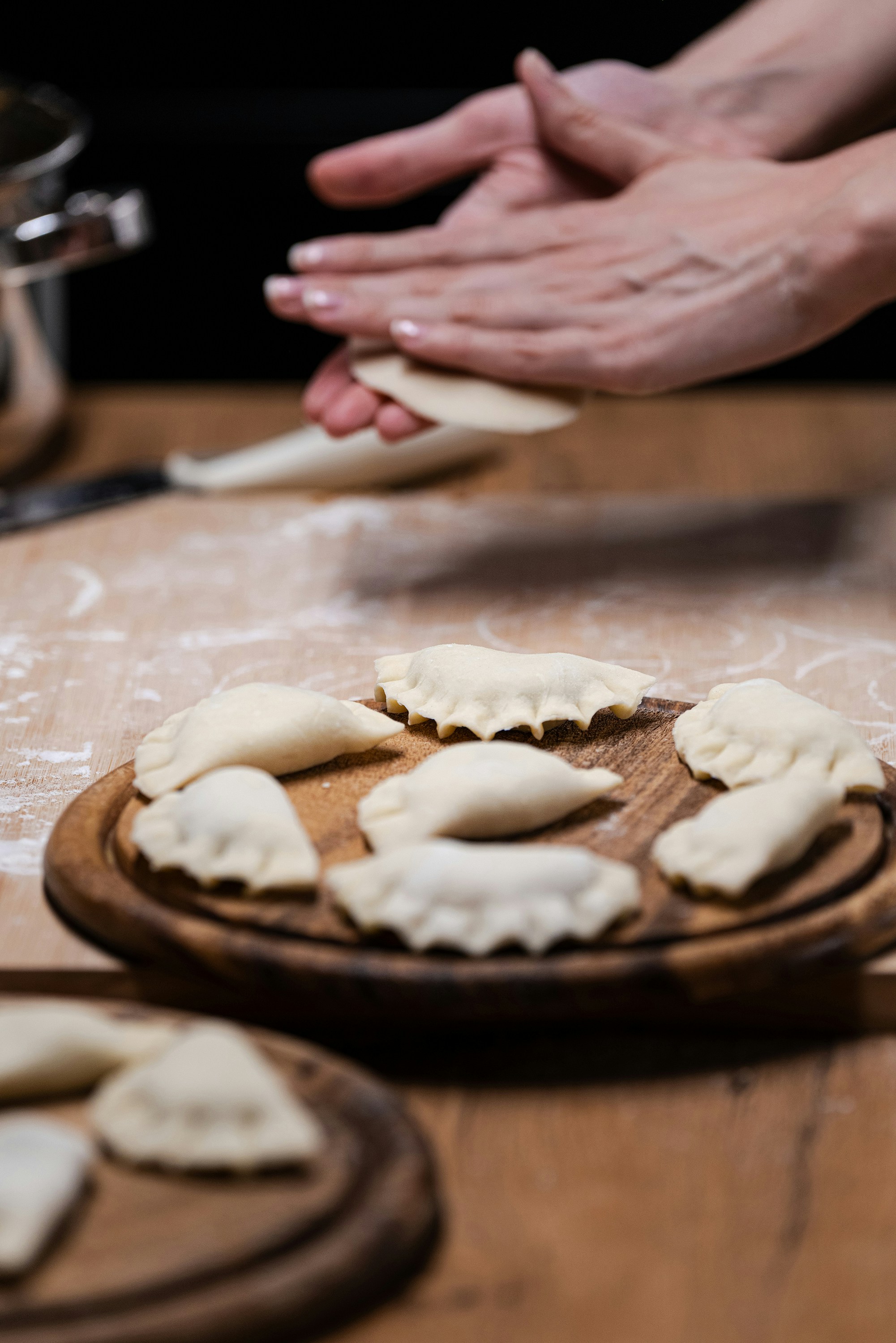 A person is making dumplings on a wooden table photo – Free Food Image ...