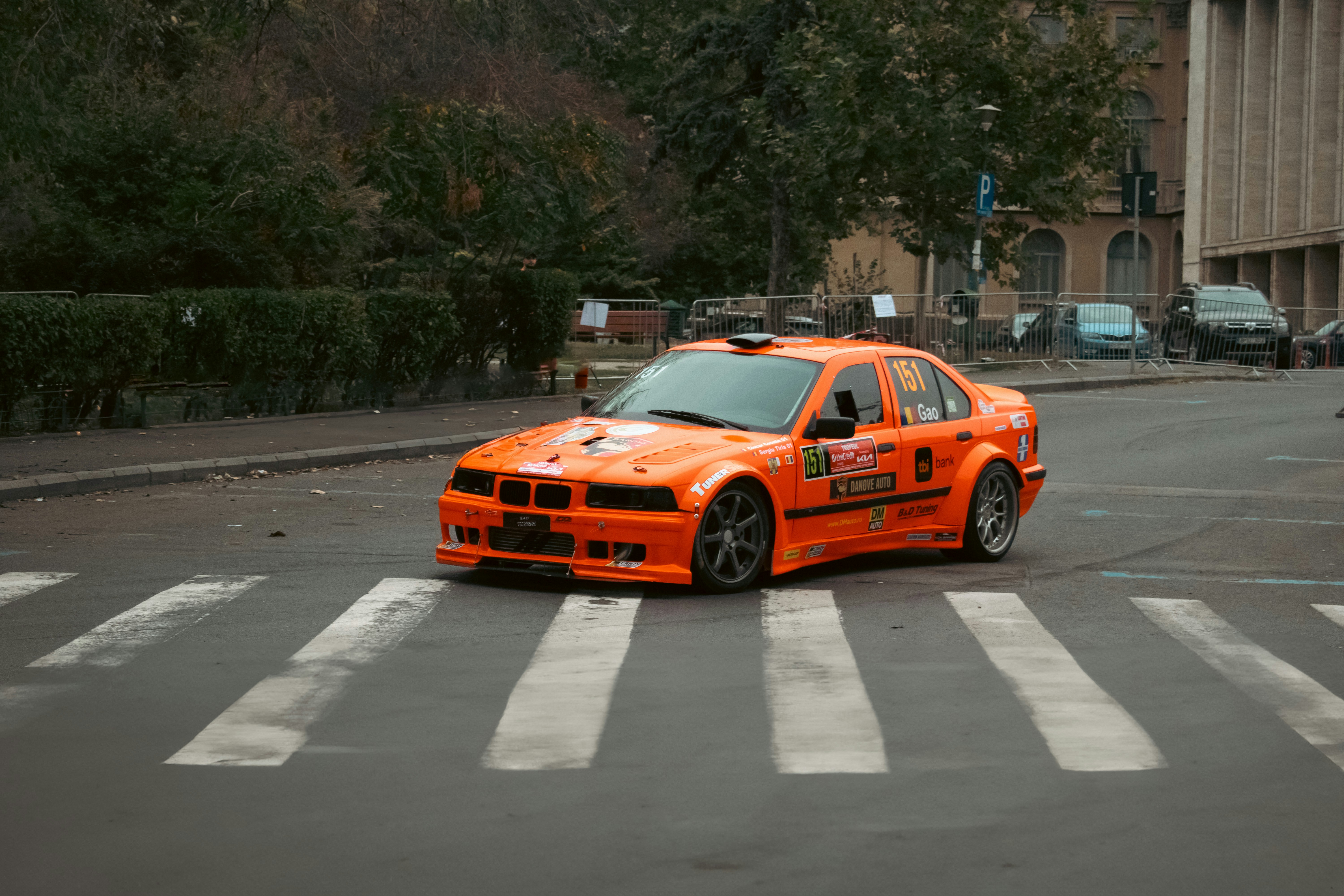 Urban Crosswalk Sprint: An Orange Racing Car Across the City Street
