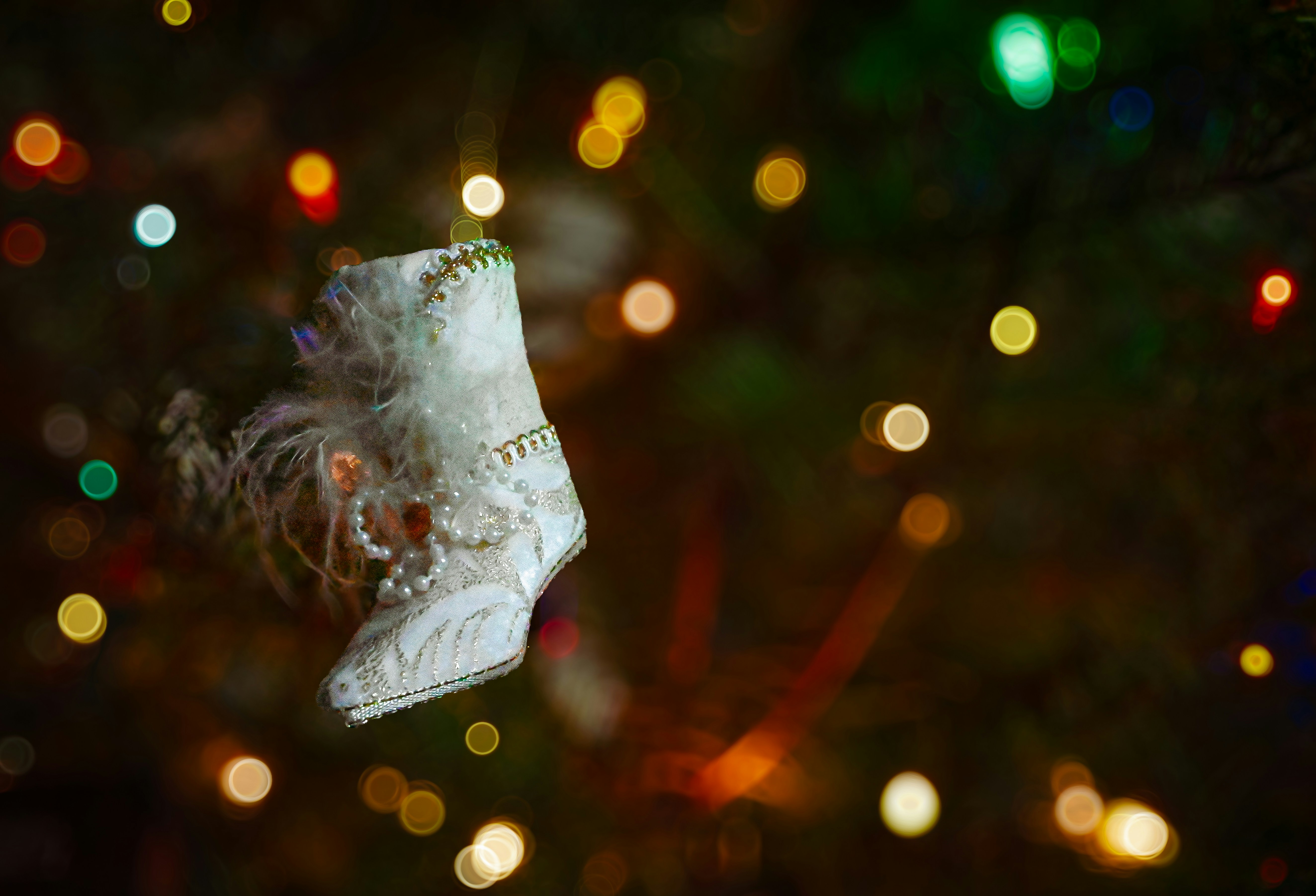 A pair of white shoes hanging from a christmas tree