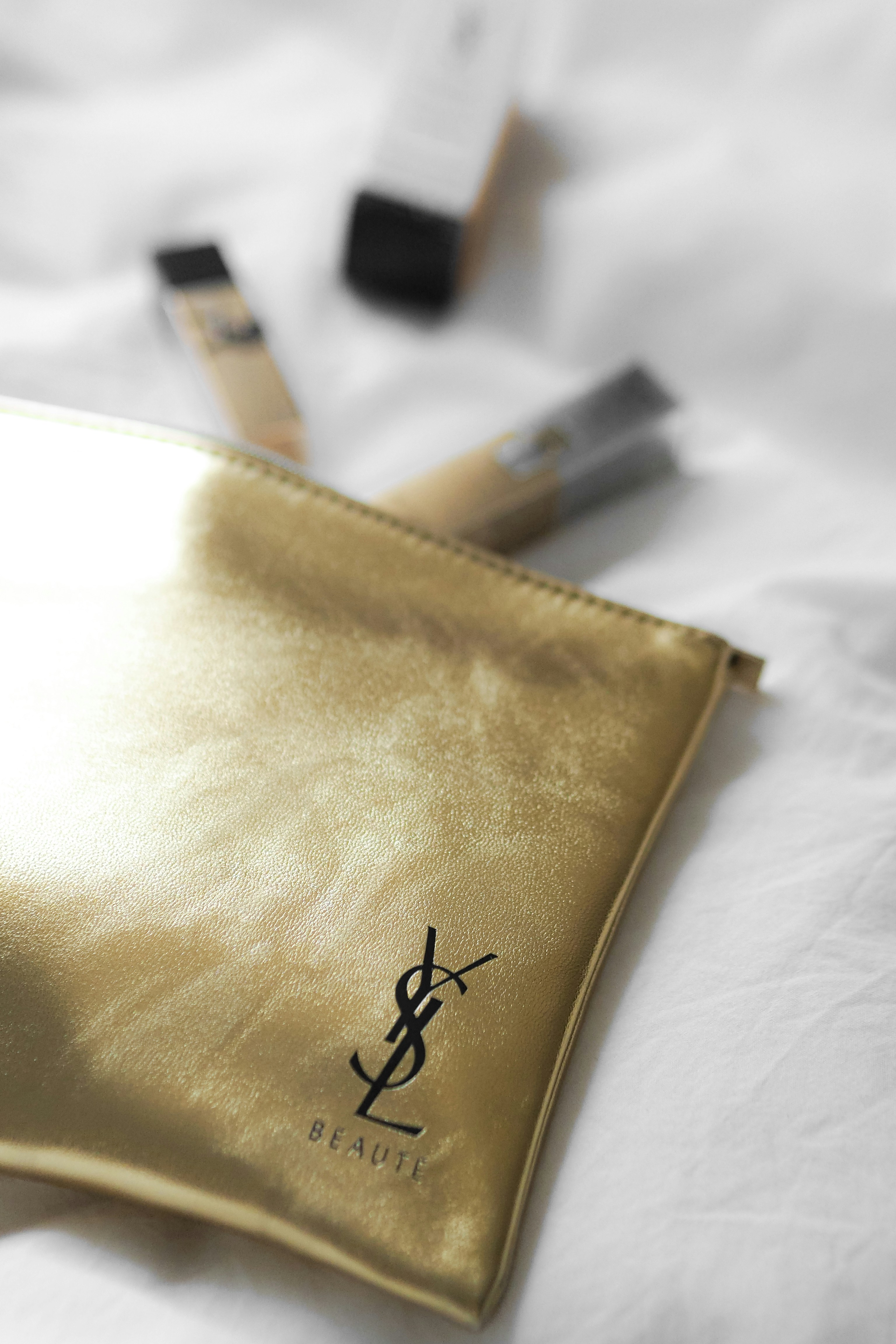 A gold pouch sitting on top of a bed photo – Free Cushion Image on Unsplash