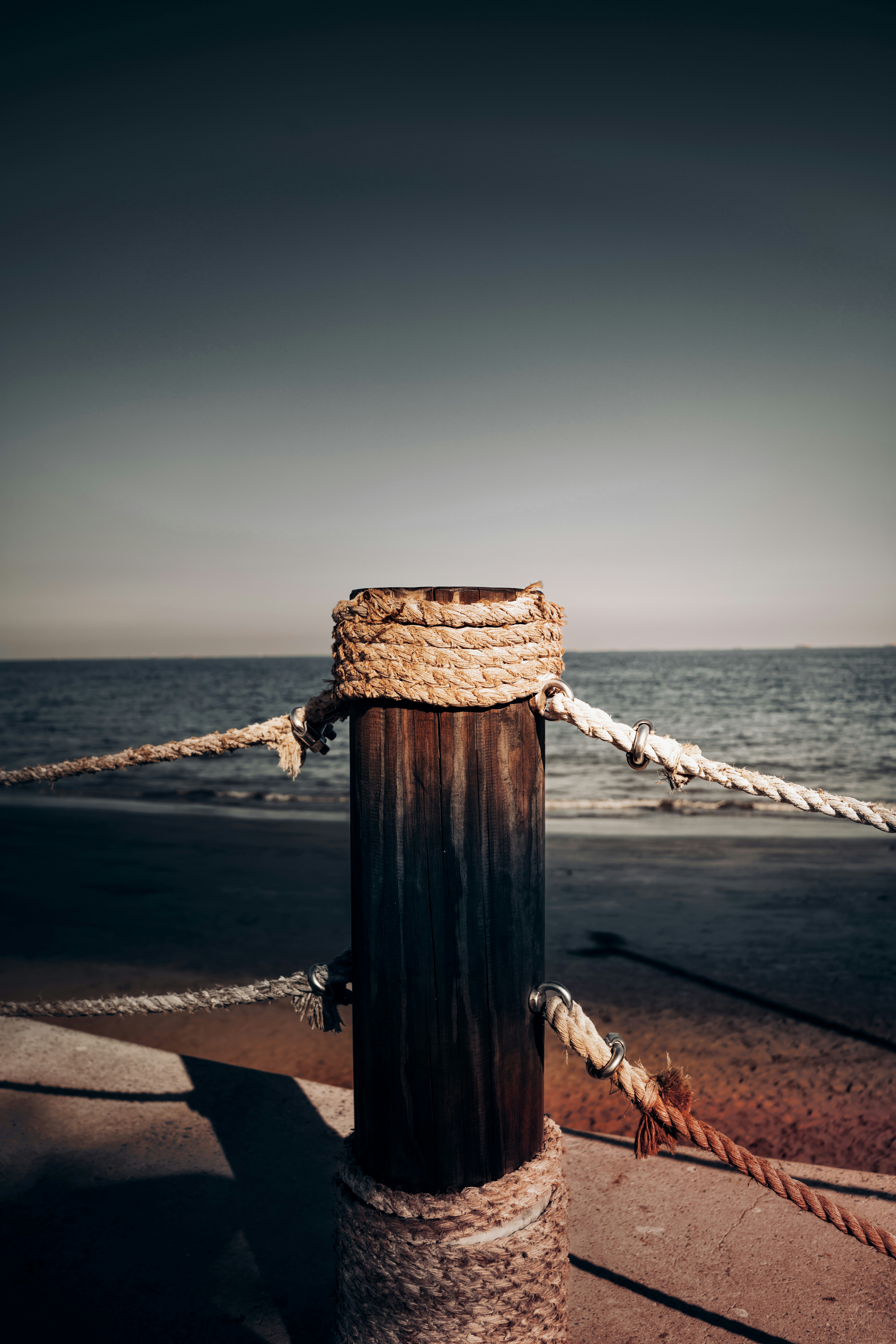 A rope tied to a post on the beach