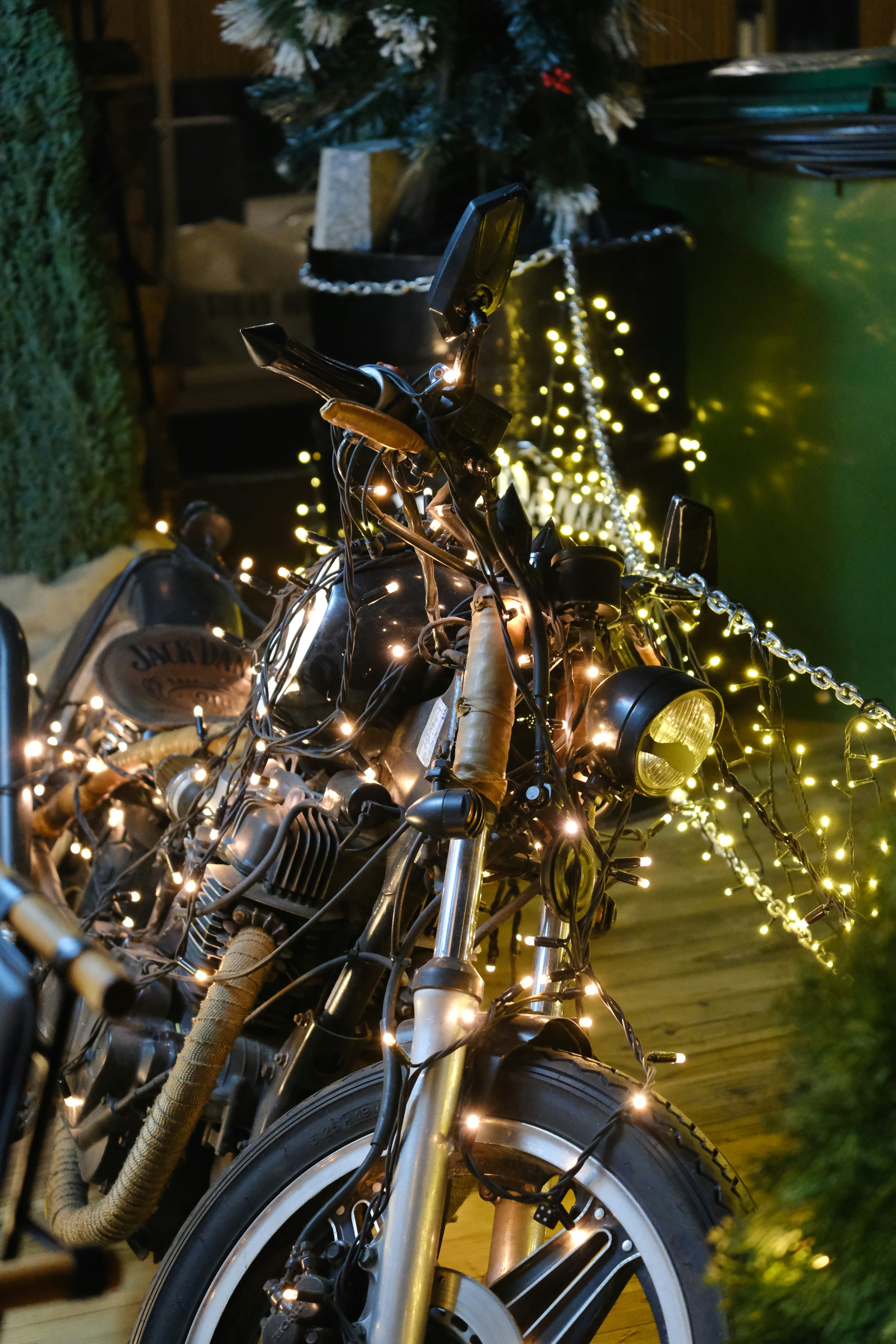 A motorcycle parked next to a christmas tree