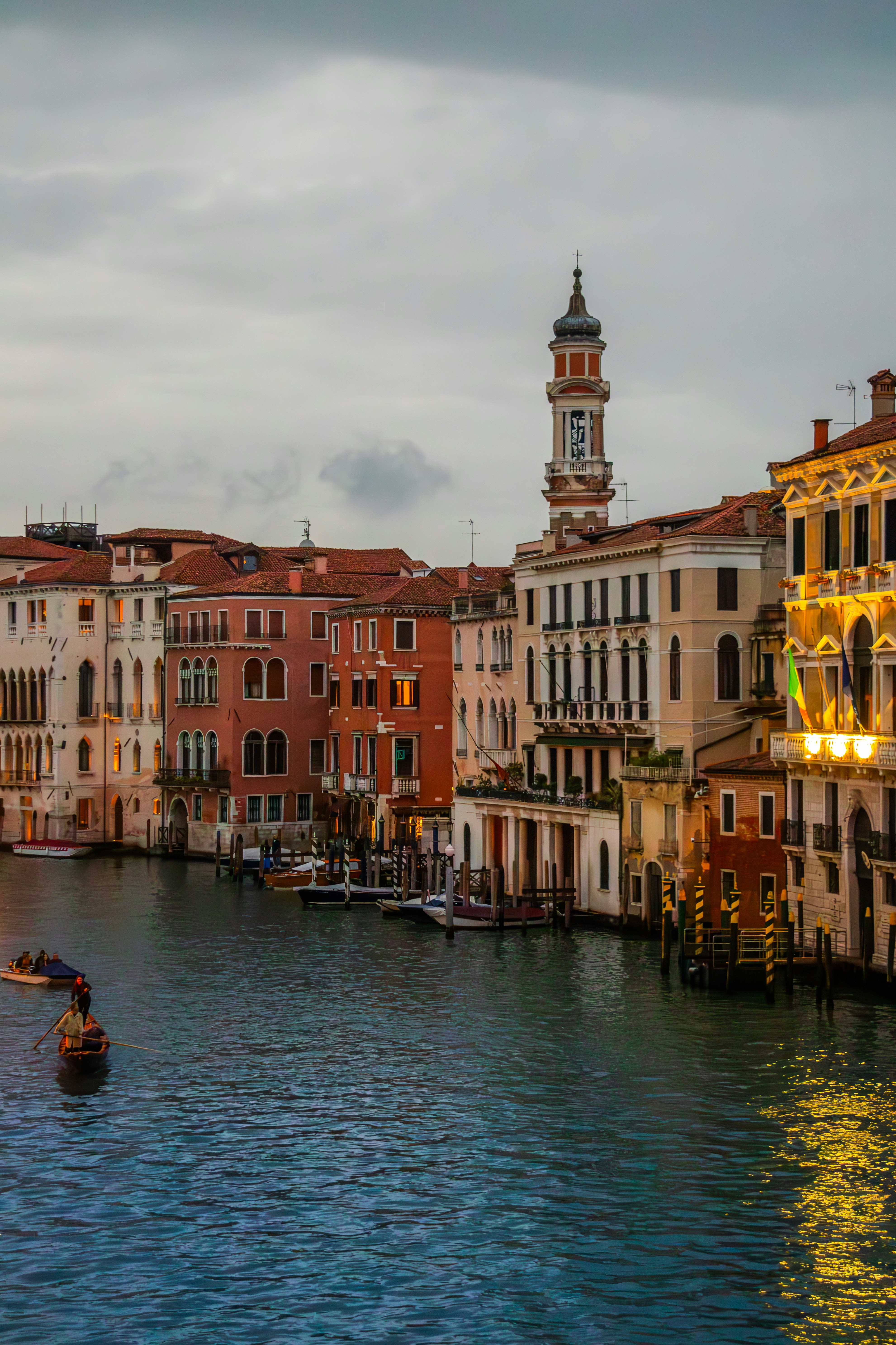 A view of a canal with buildings and a clock tower in the background ...