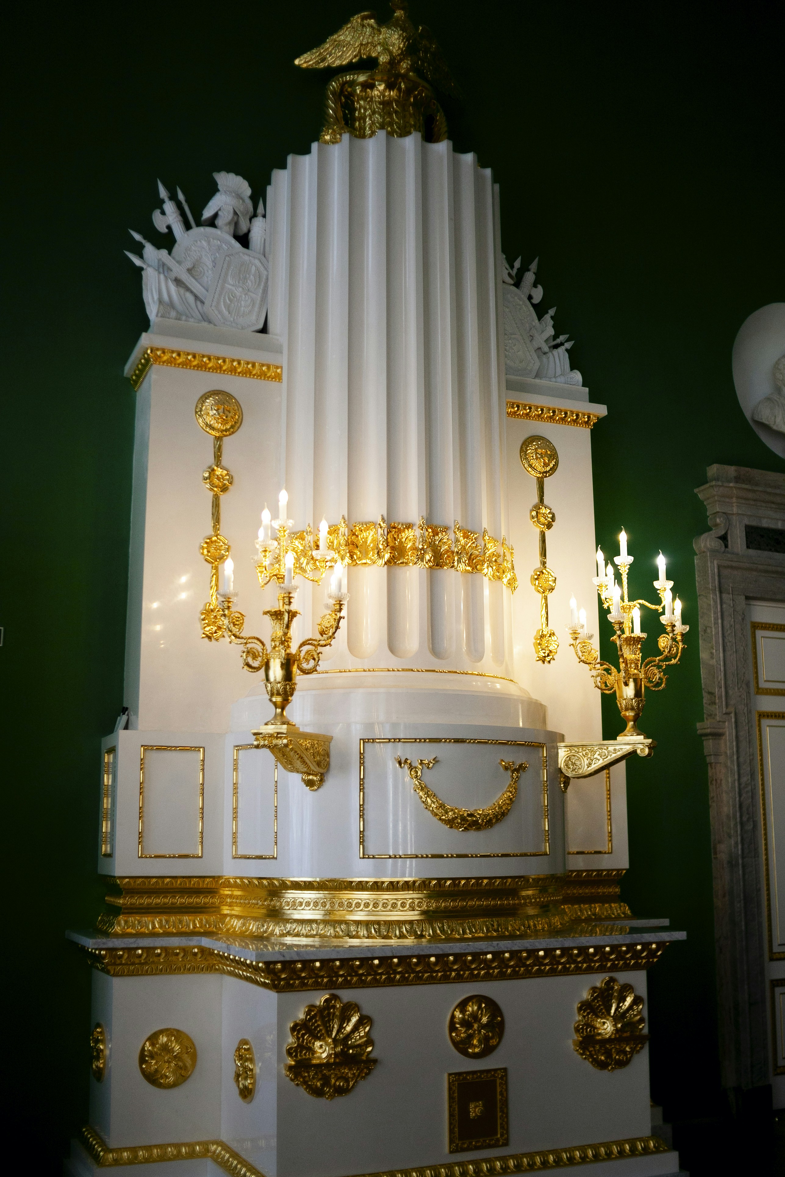 Ivory-White Altar in Gold: Candlelit Shrine Against a Green Backdrop