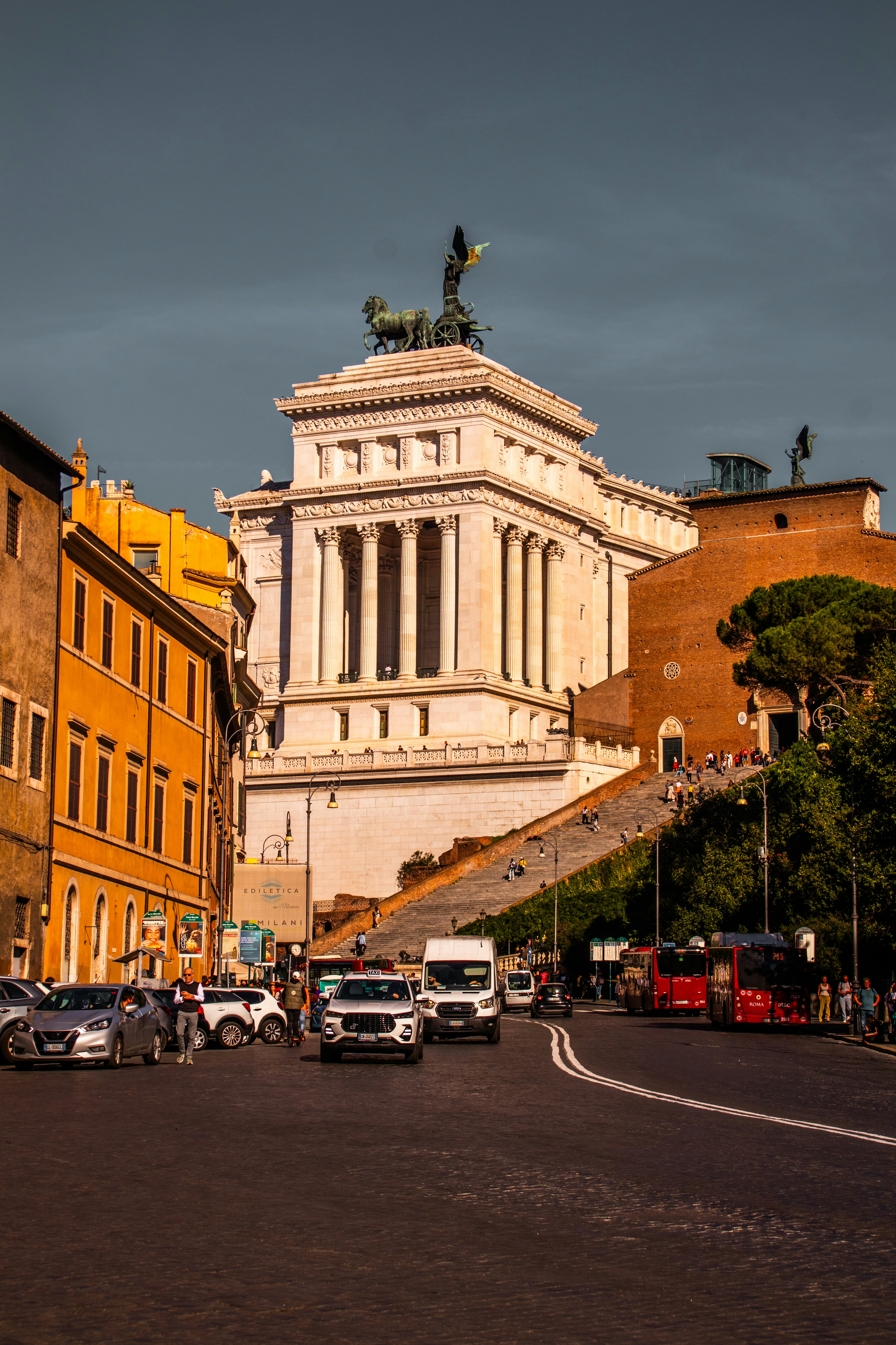 Golden Hour Quadriga: Rome’s Vittoriano Looms Over a Bustling Street