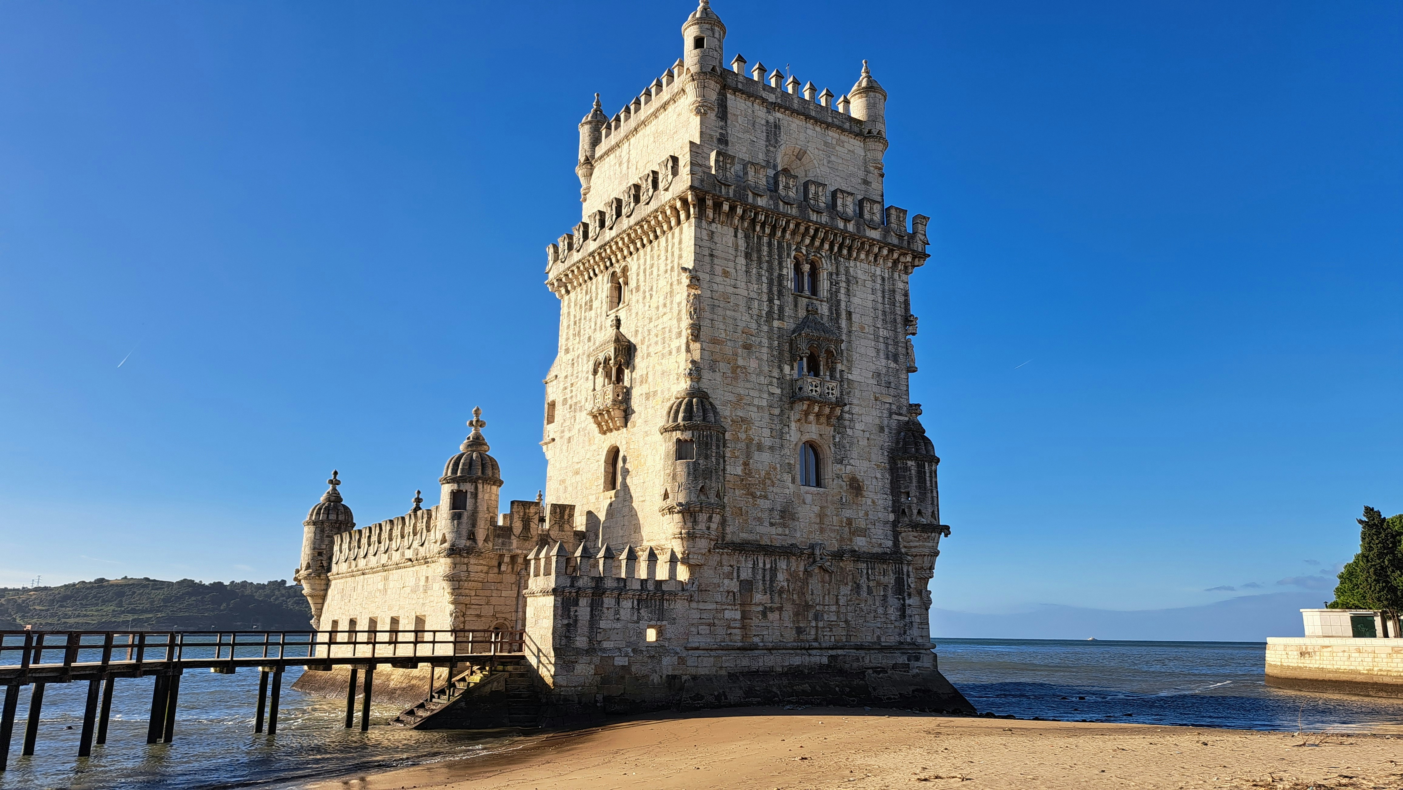 Torre de Belém, Lisbon, Portugal | A large tower sitting on top of a sandy beach