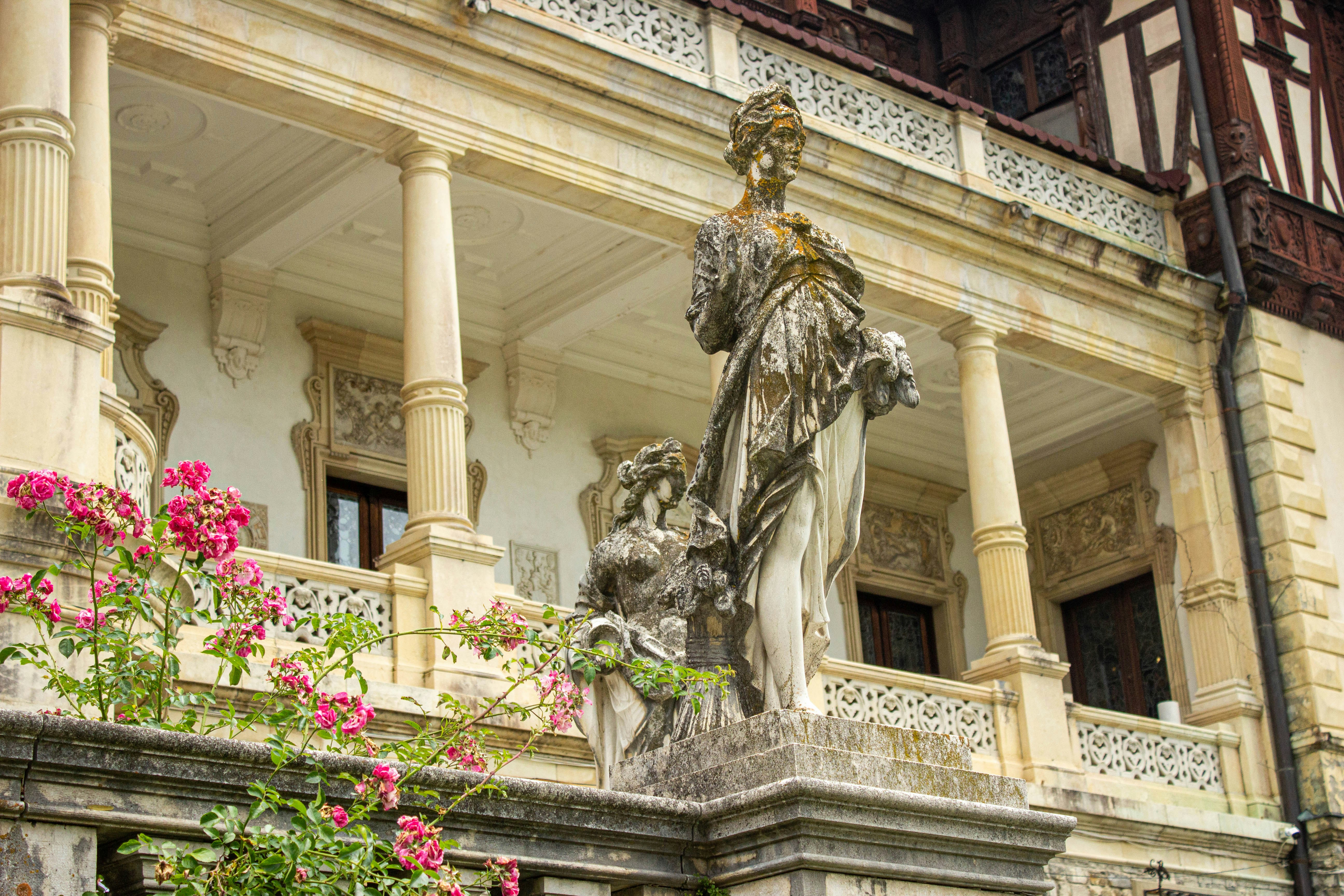 Statue Guardian Over a Sunlit Balcony Framed by Pink Roses