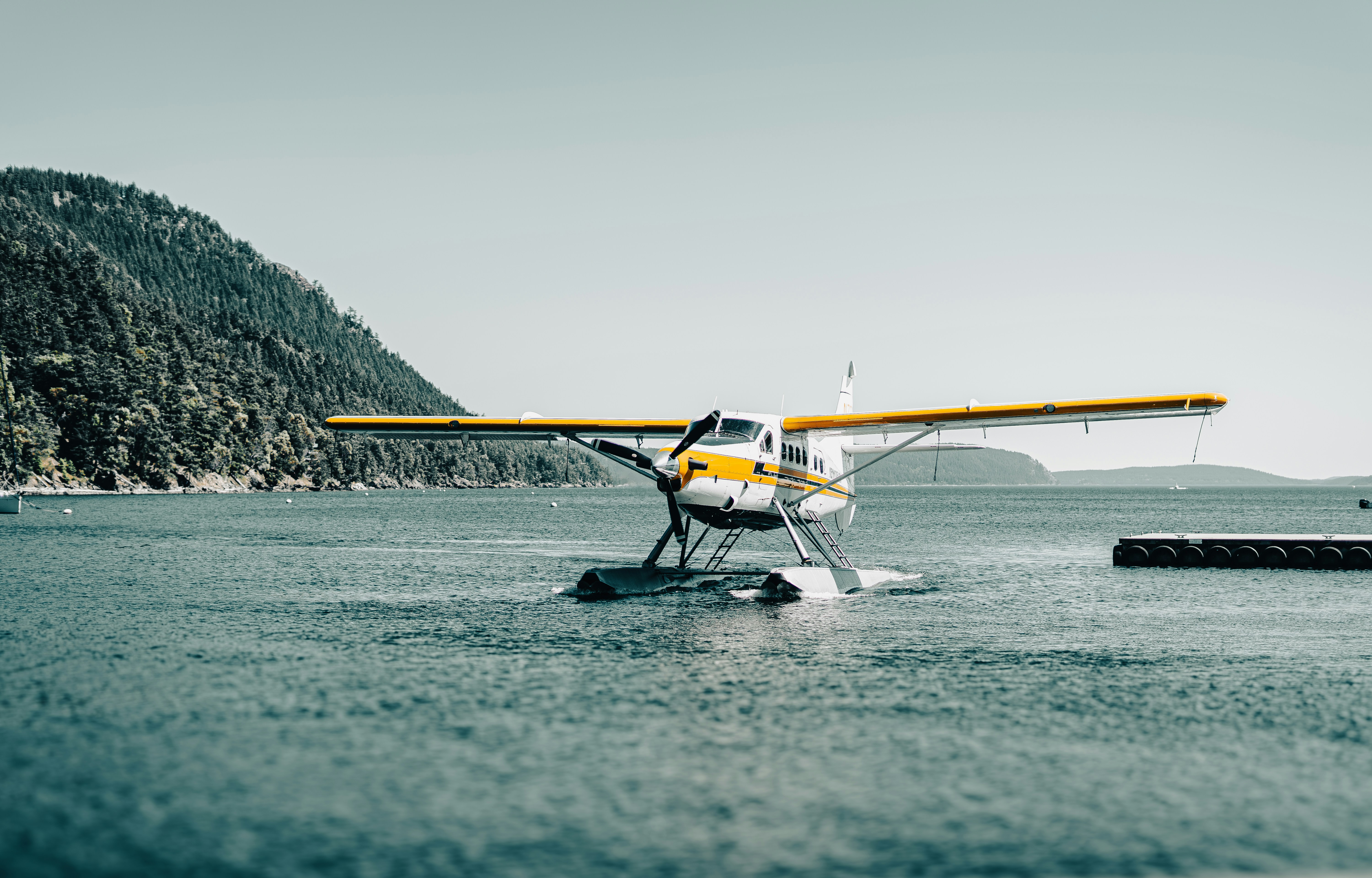 A small plane sitting on top of a body of water photo – Free Airplane ...