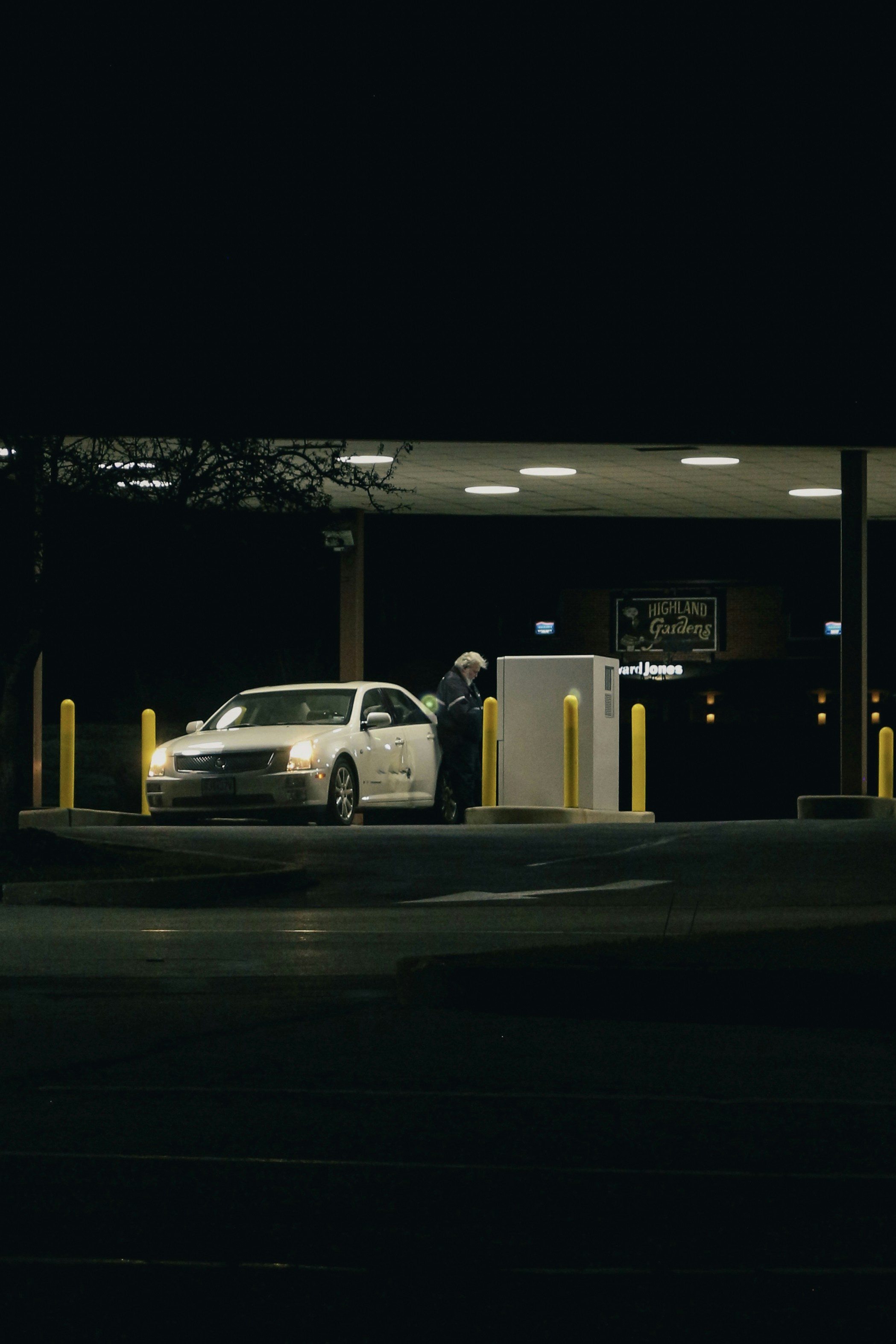 Midnight Stop: White Sedan at the Quiet Gas Canopy