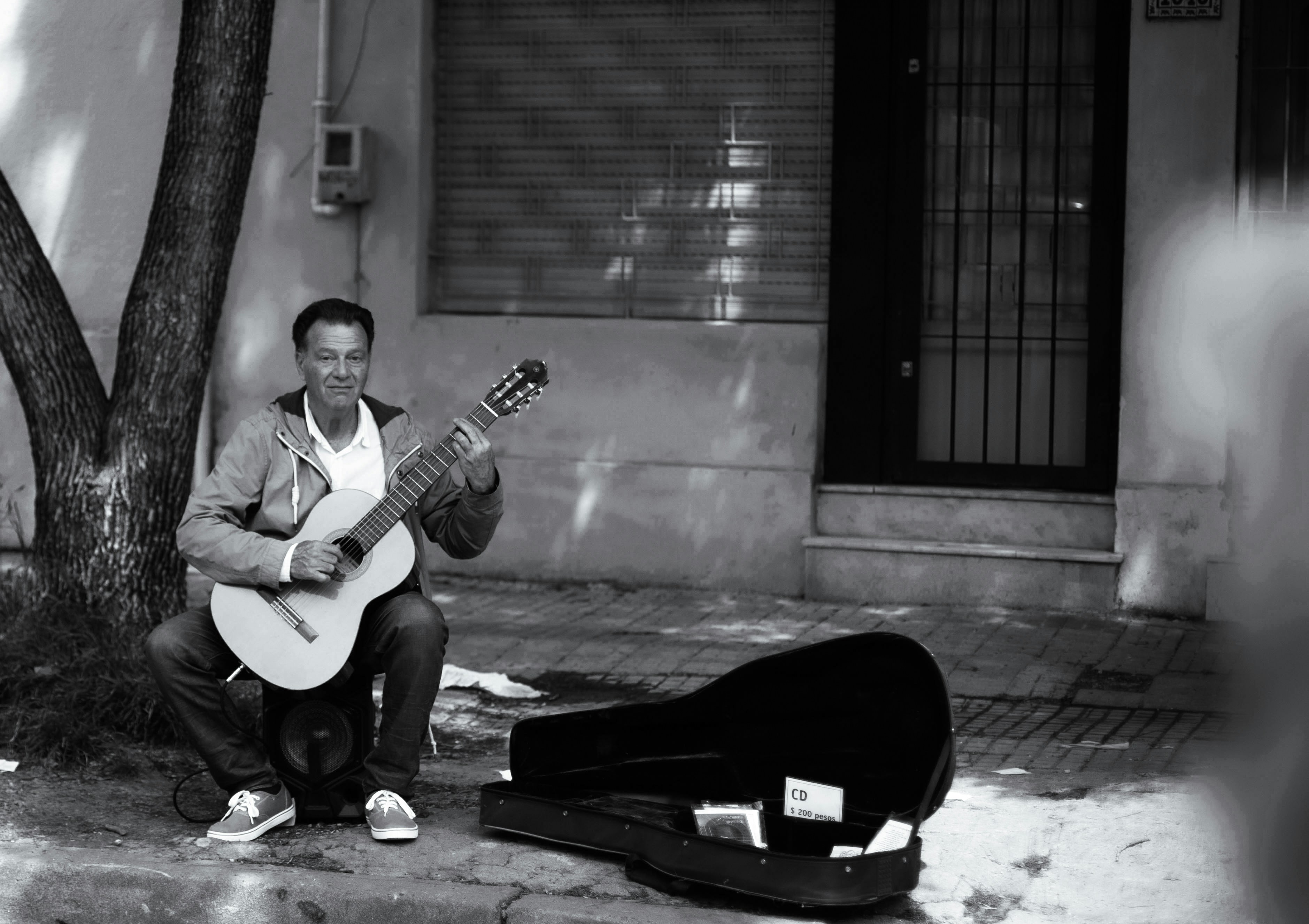 Gray Street Serenade: A Guitarist, Open Case, Daylight Shadows