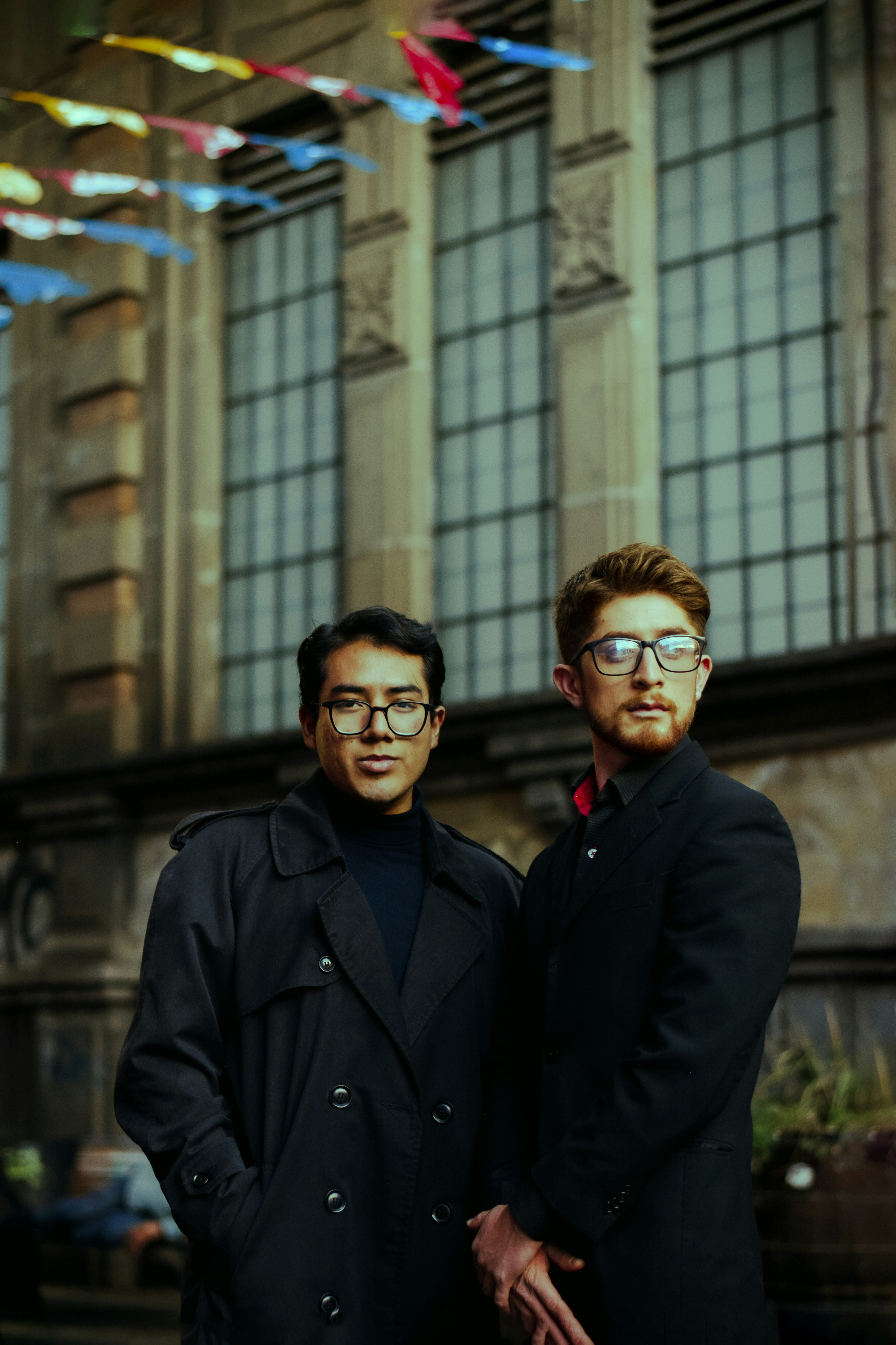 Two men standing next to each other in front of a building photo – Free ...