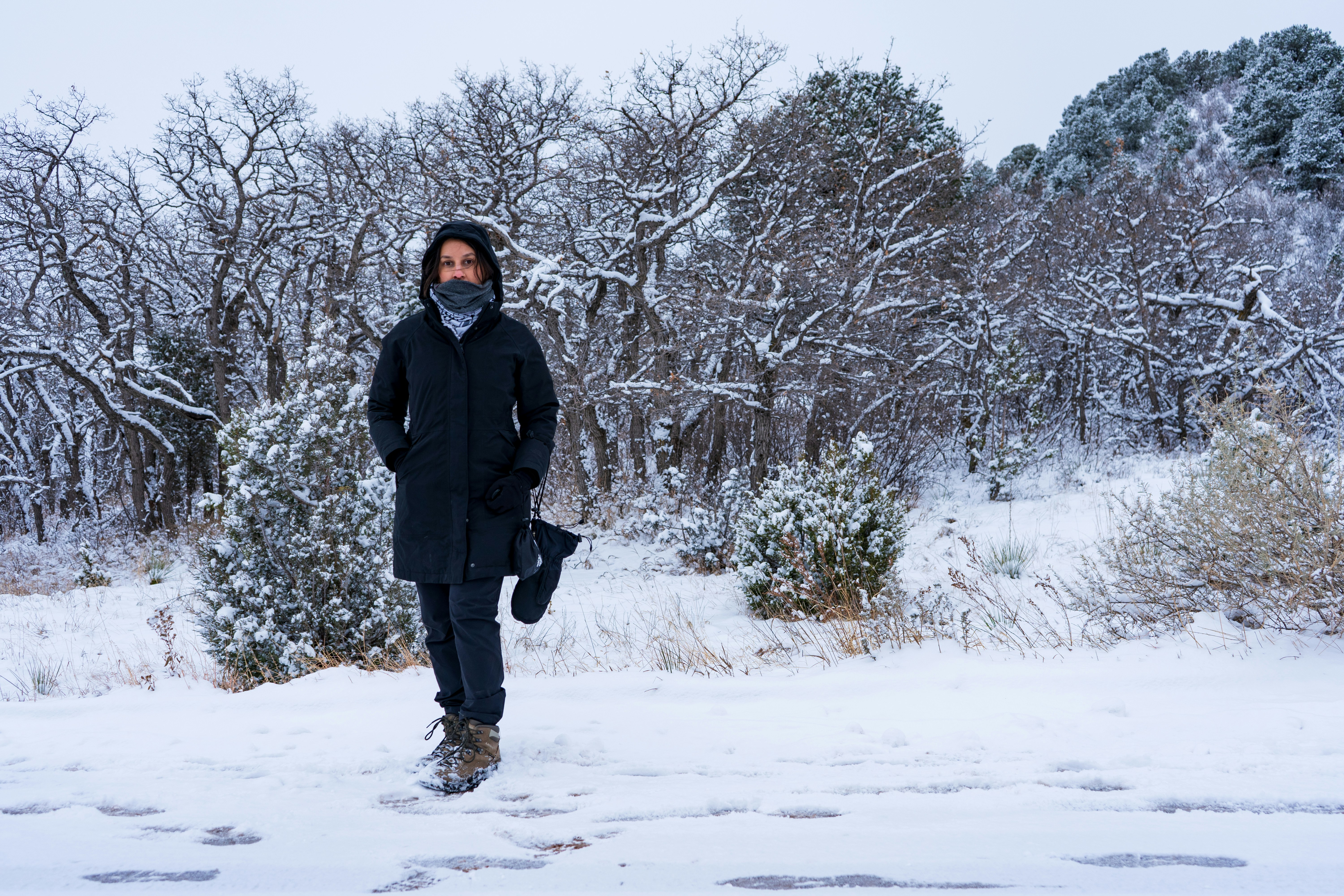 A man in a black coat is walking through the snowDennis Thompson