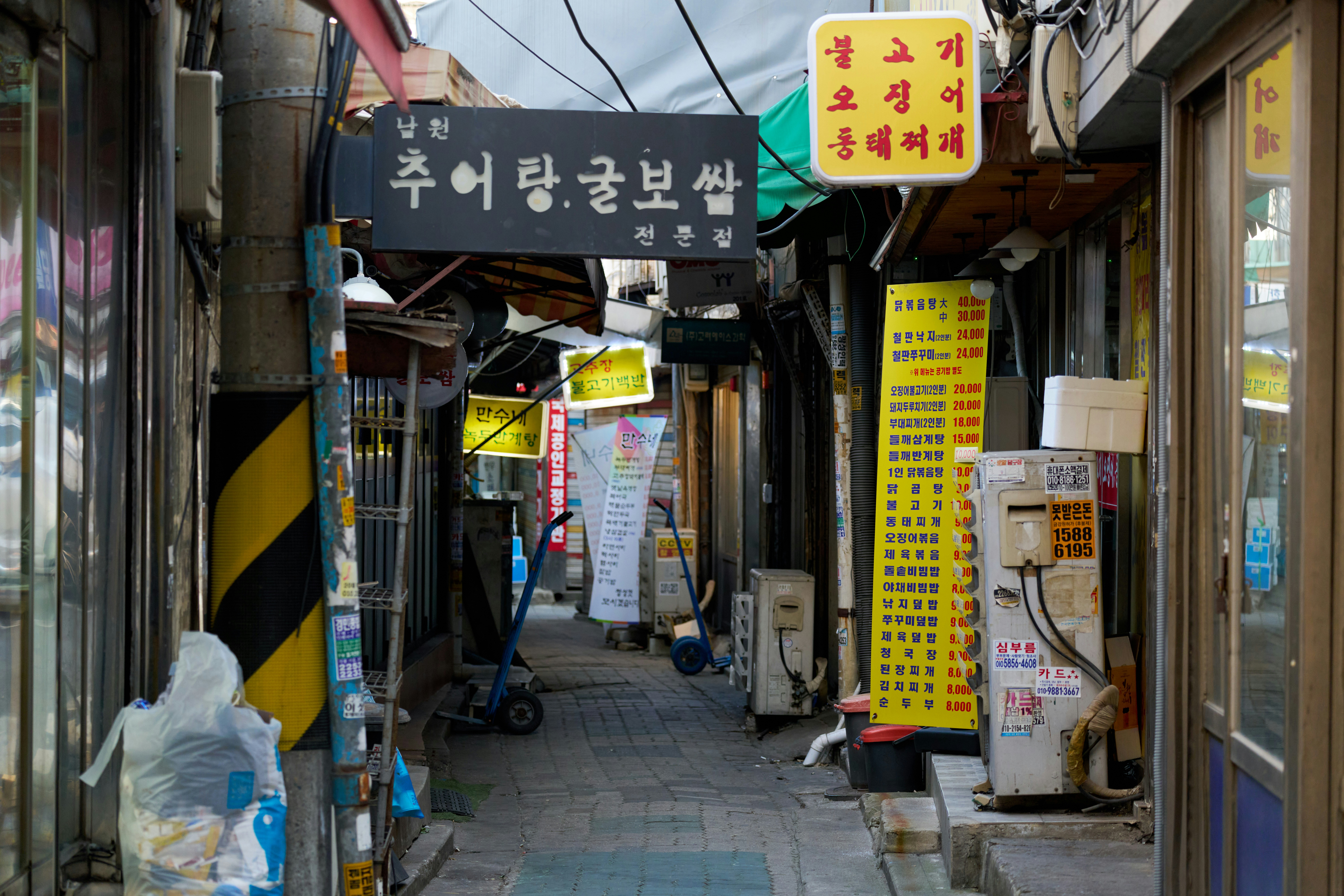 A narrow alley way with signs on the buildings photo – Free Woman Image ...