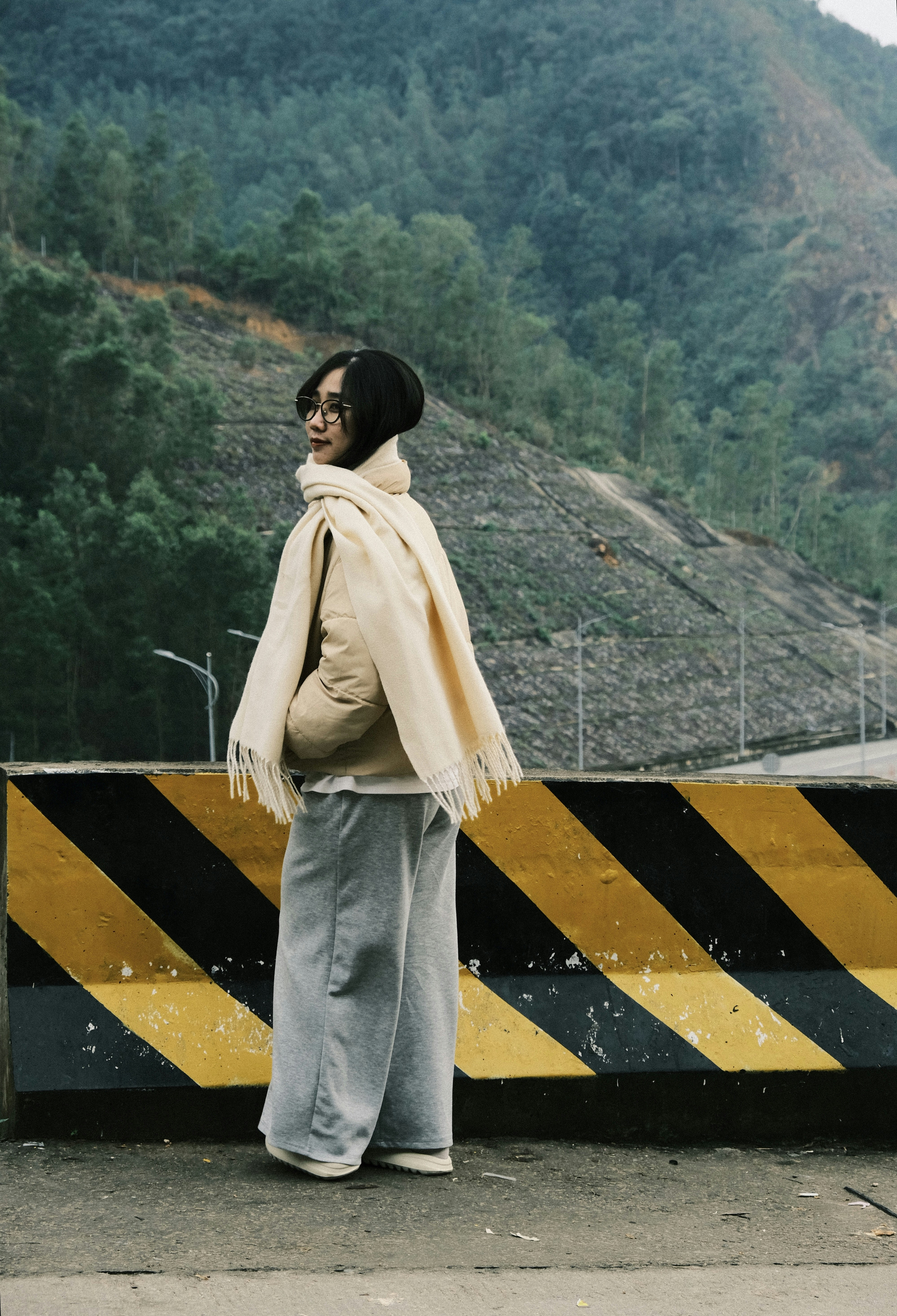 Wrapped in Warmth: A Portrait Against a Mountain Highway