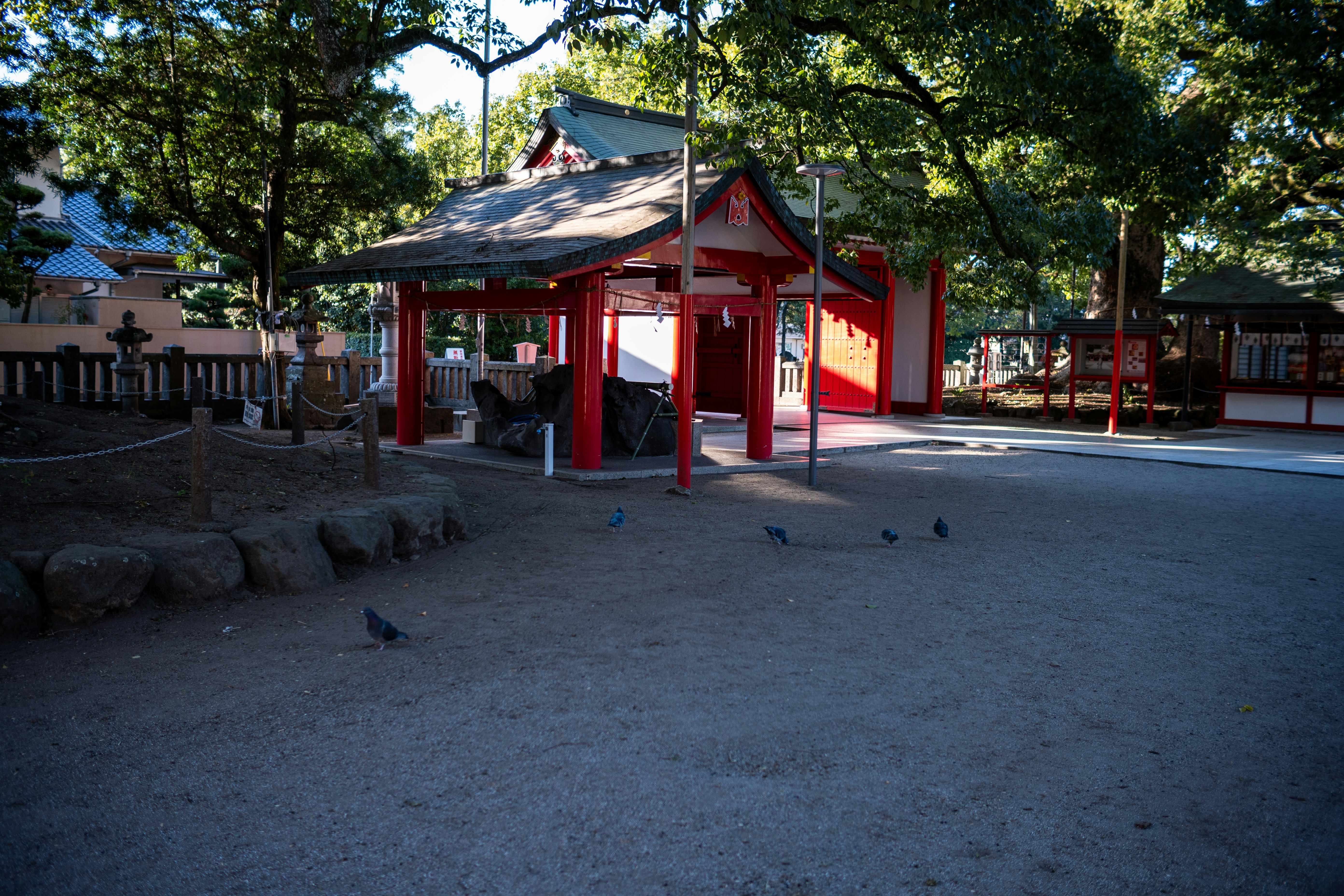 A small red building in the middle of a park photo – Free House Image ...