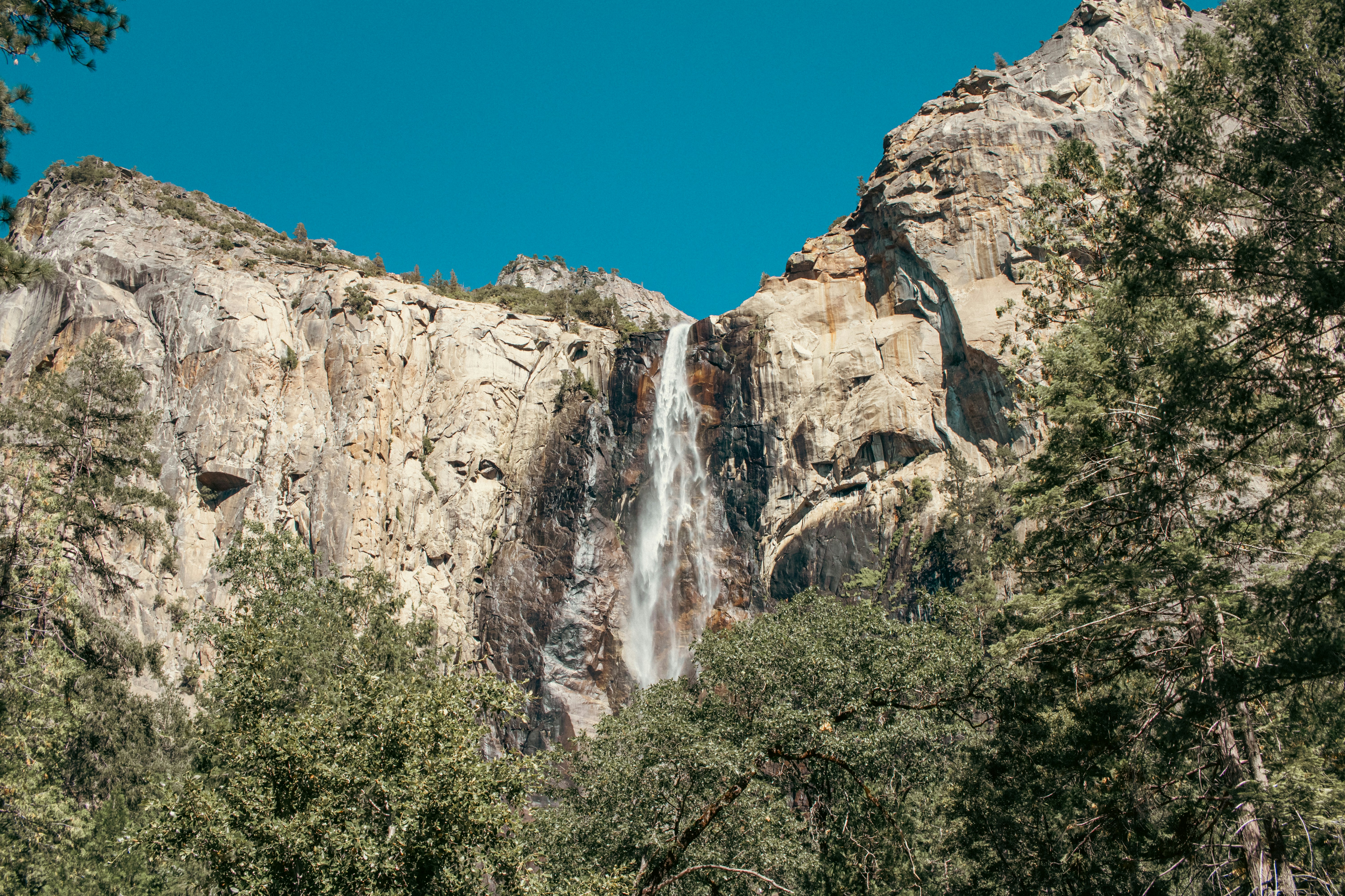 A waterfall is seen from the bottom of a cliff photo – Free Bridalveil ...