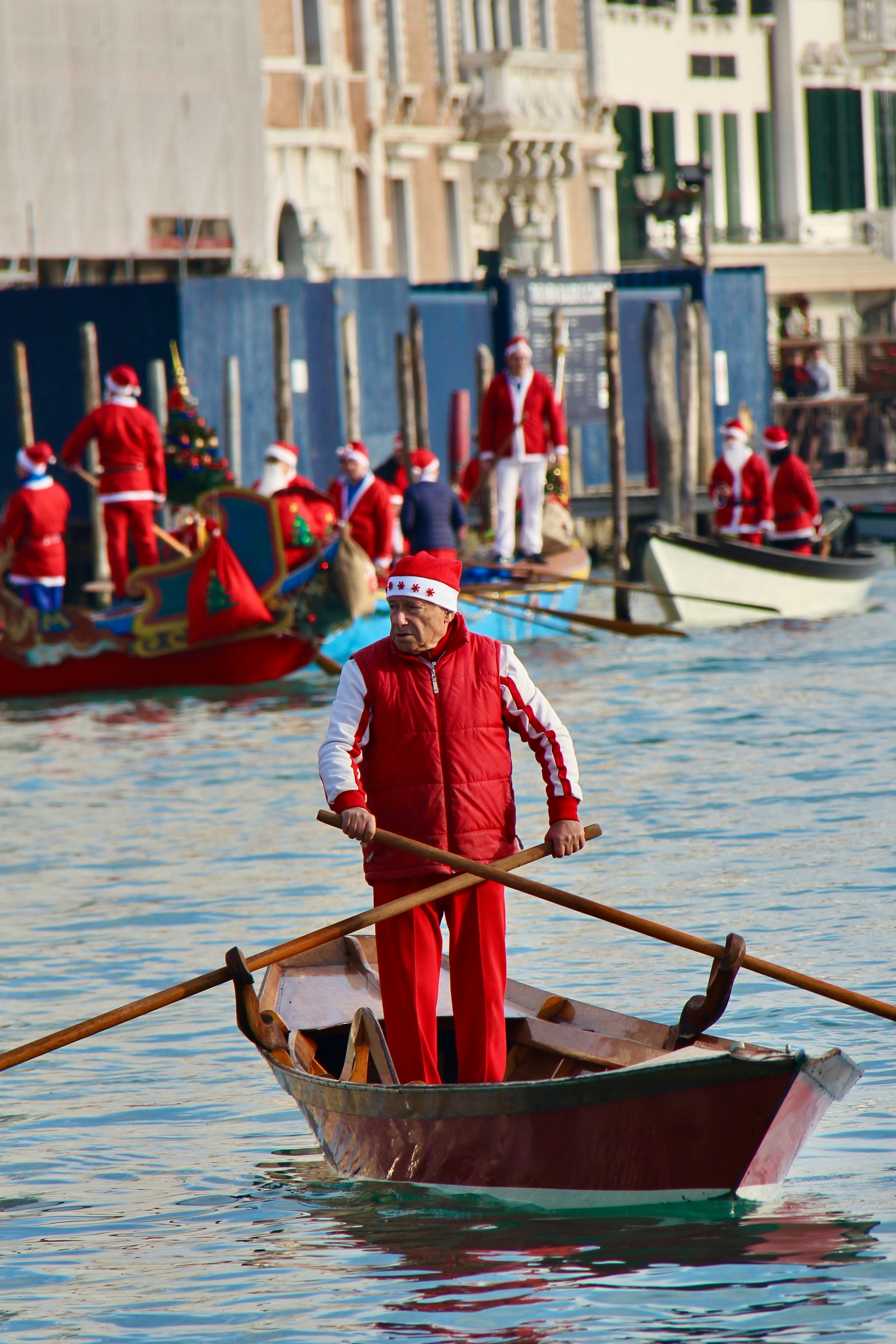 Vibrant Gondolier Parade: Santa Costumes on the Venetian Canal
