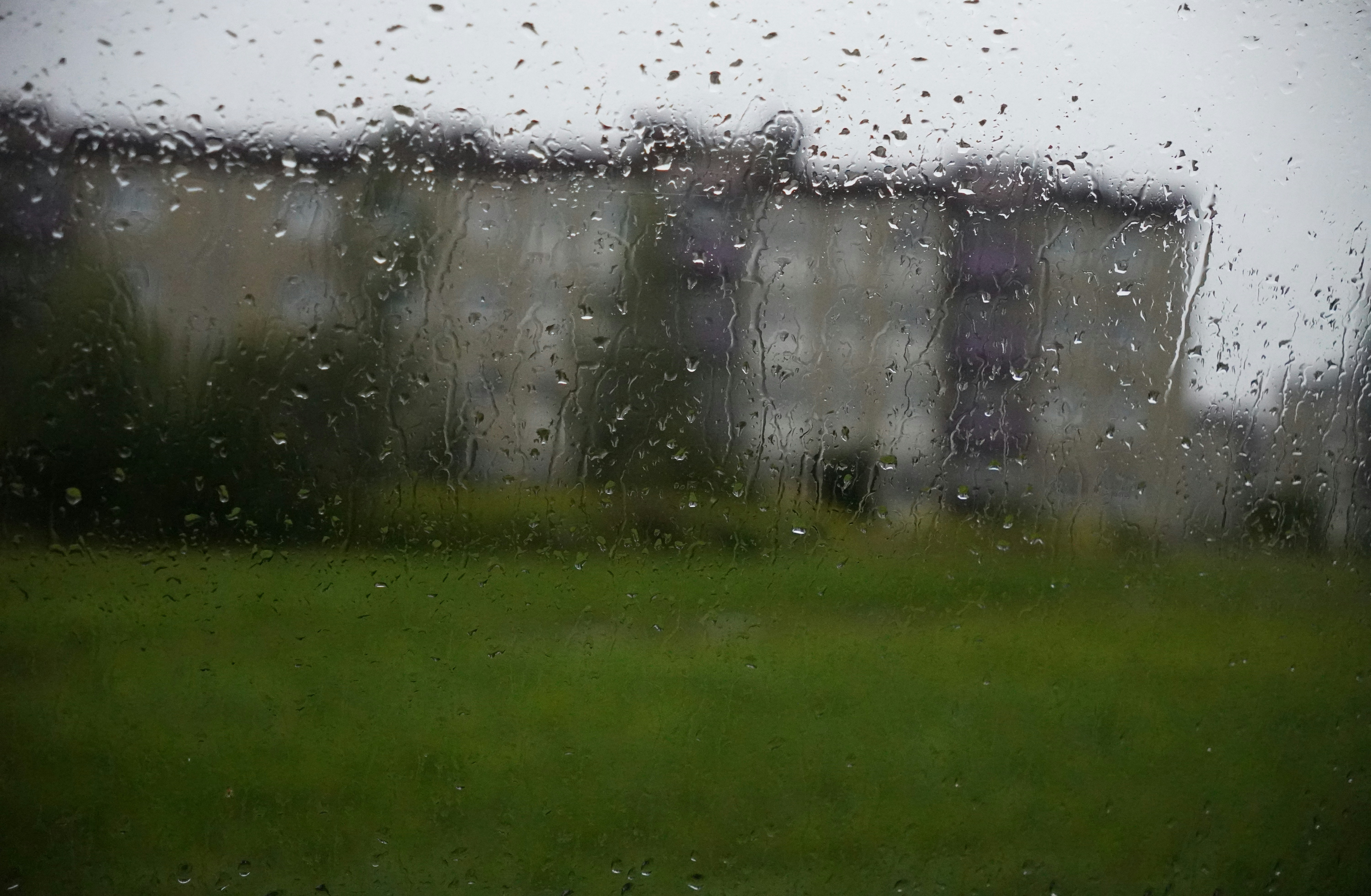 A view of a building through a rain covered window photo – Free Rain ...