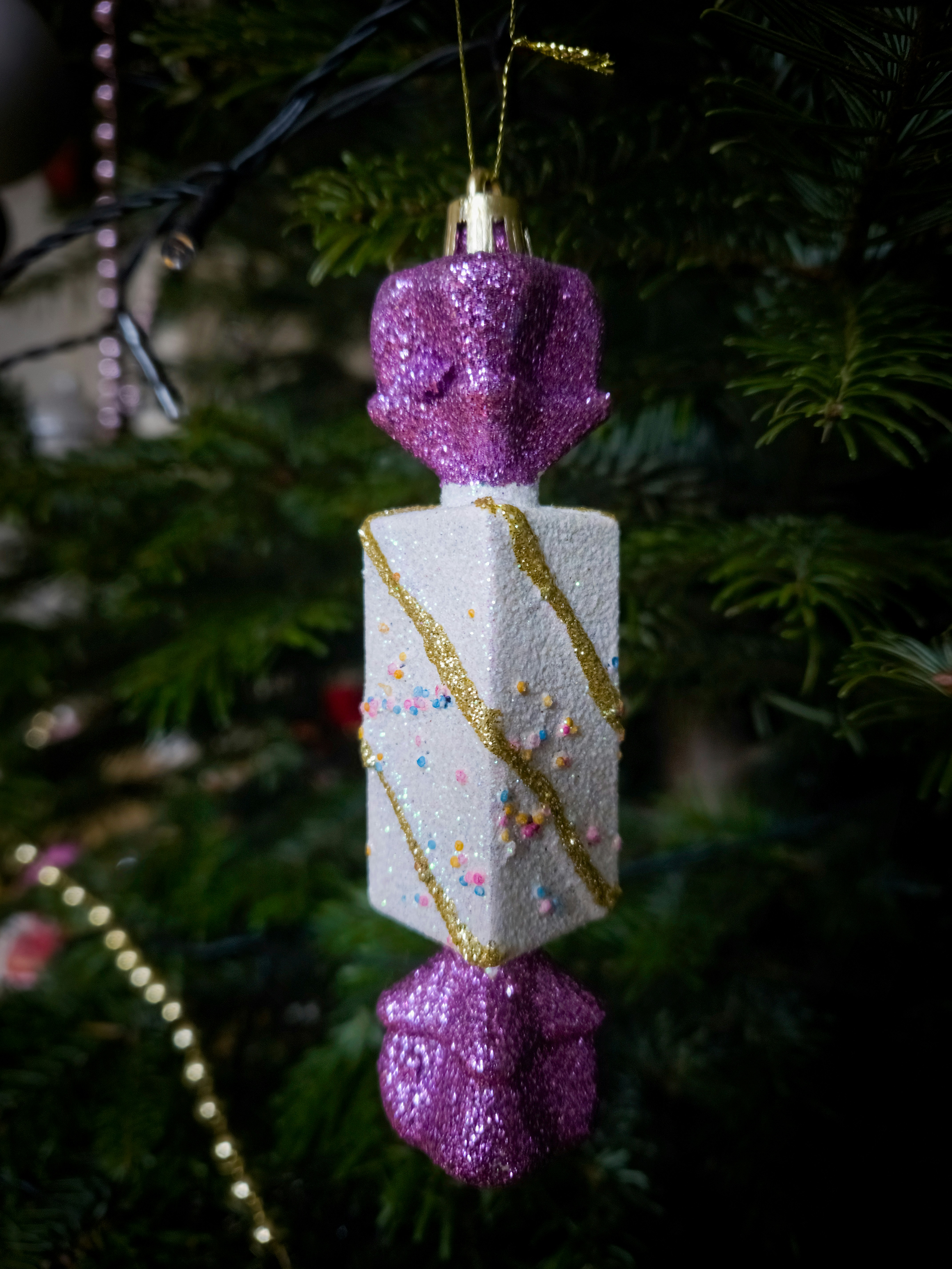 Candy-Glitter Ornament Draped in Purple on a Christmas Tree