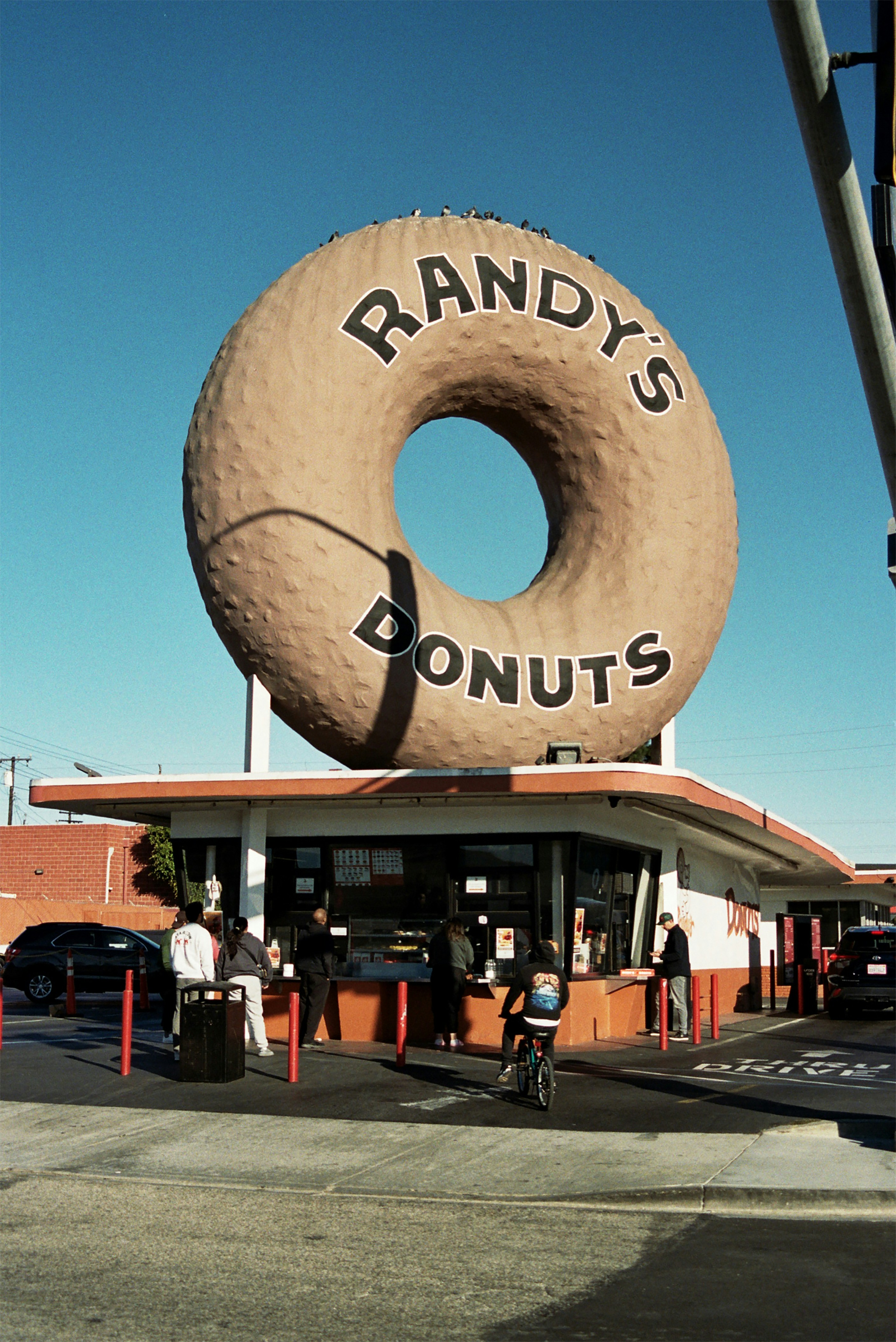 A giant donut sitting on top of a donut shop photo – Free Inglewood ...