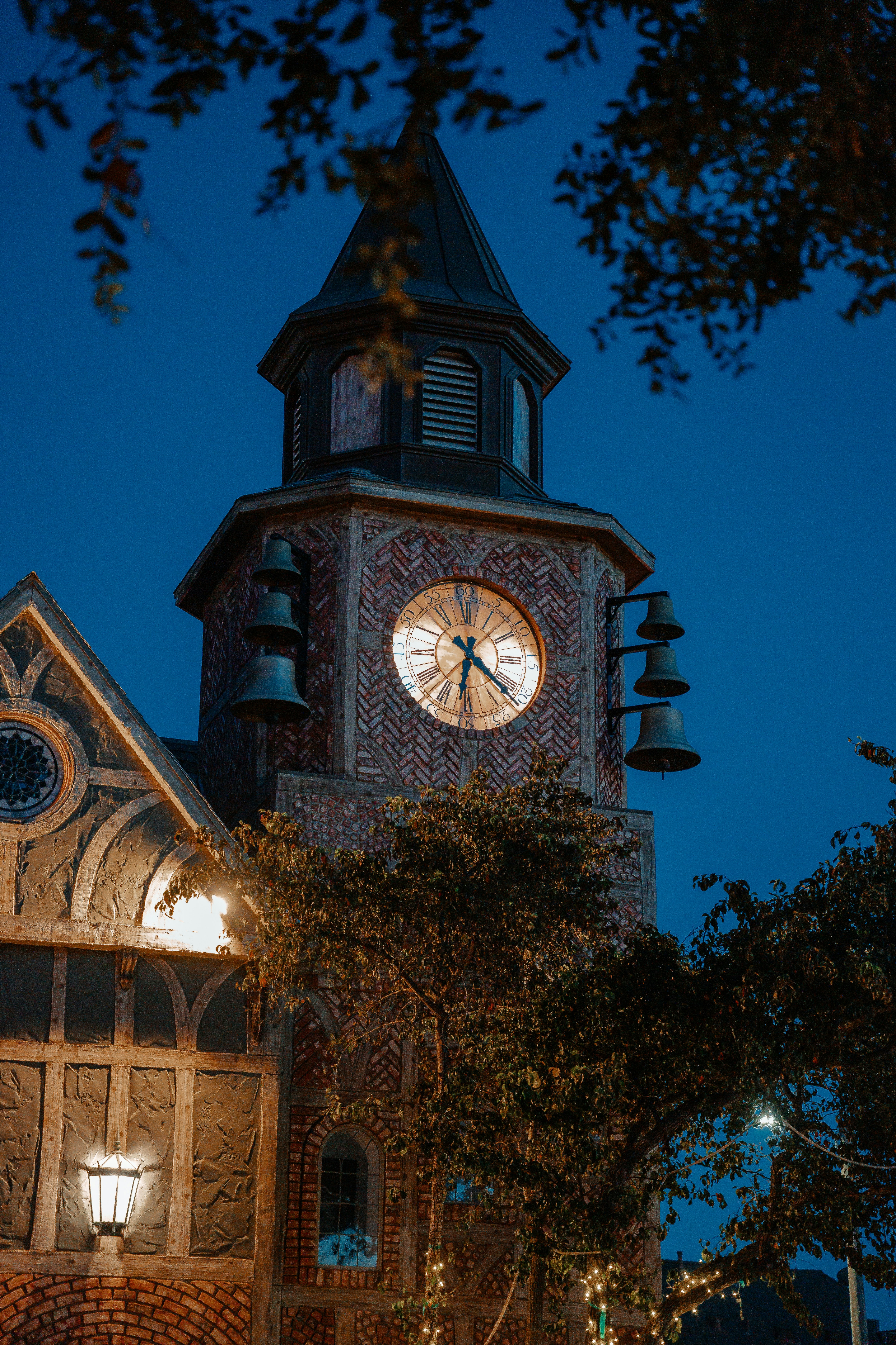 Blue Hour Clock Tower: Warm Lanterns Framing a Brick Spire