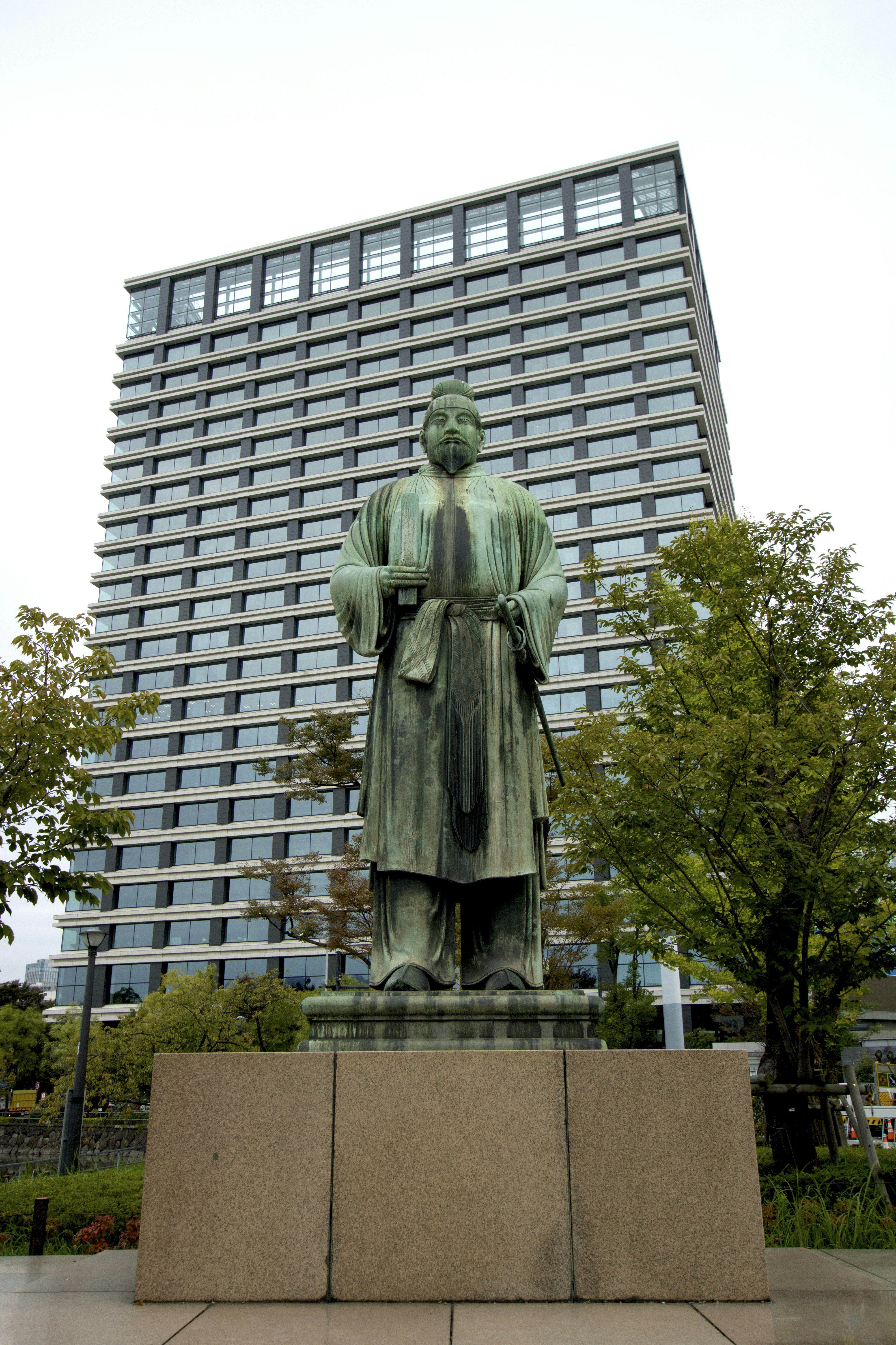 Confucian Guardian: Bronze Sage Framed by a Glass Facade