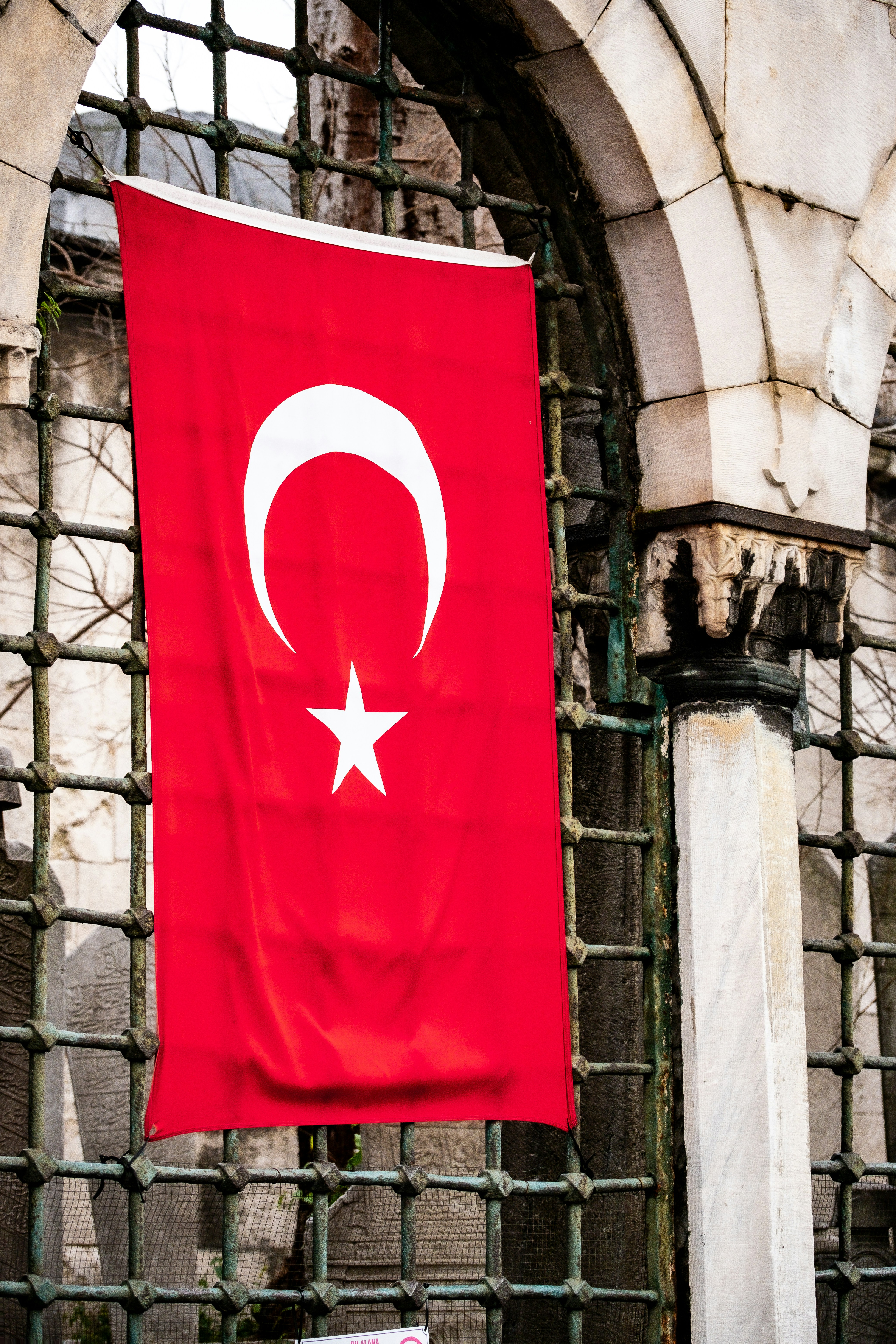 Red Banner with Crescent and Star Framed by a Weathered Archway