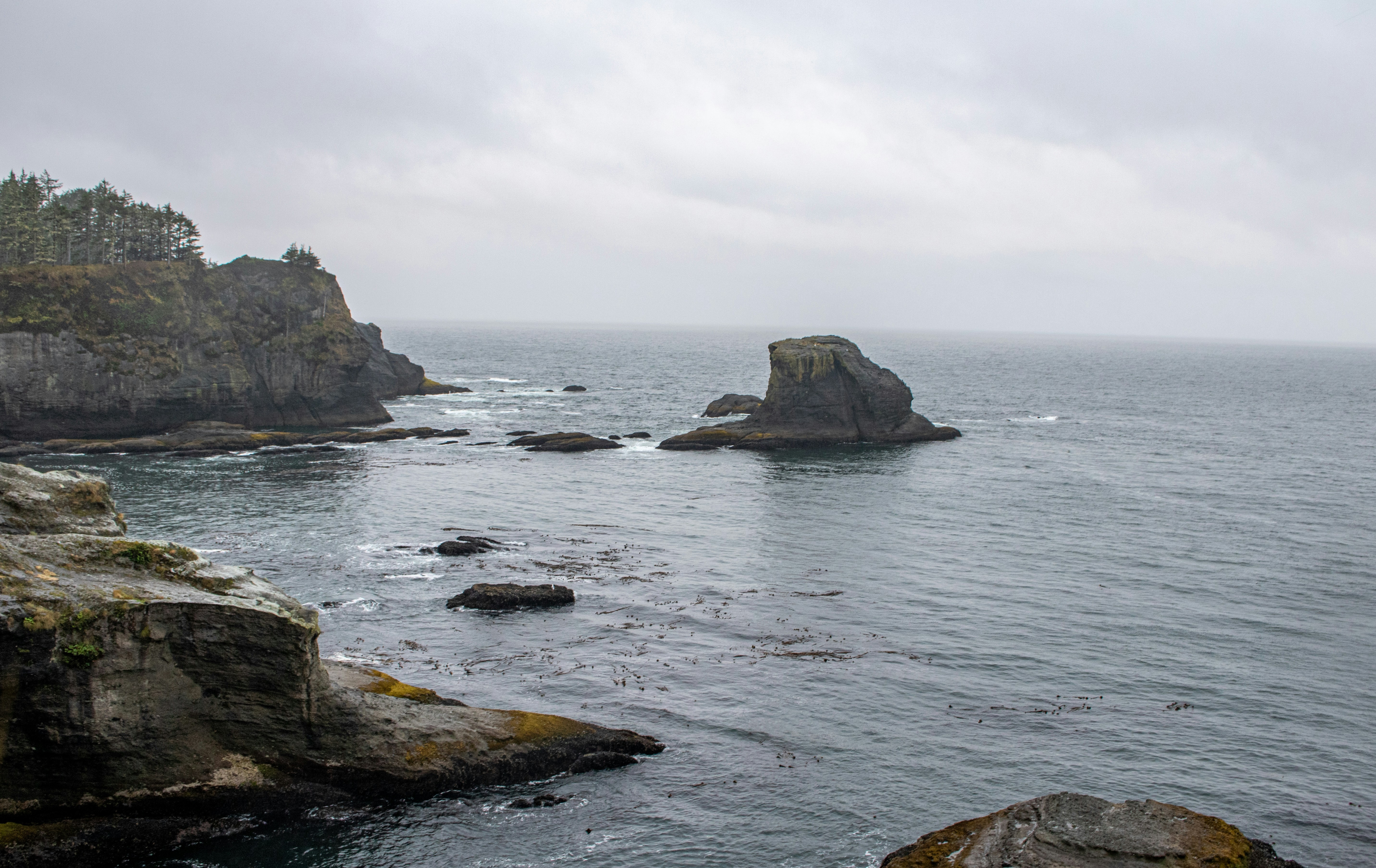 A body of water surrounded by rocks on a cloudy day photo – Free Hiking ...