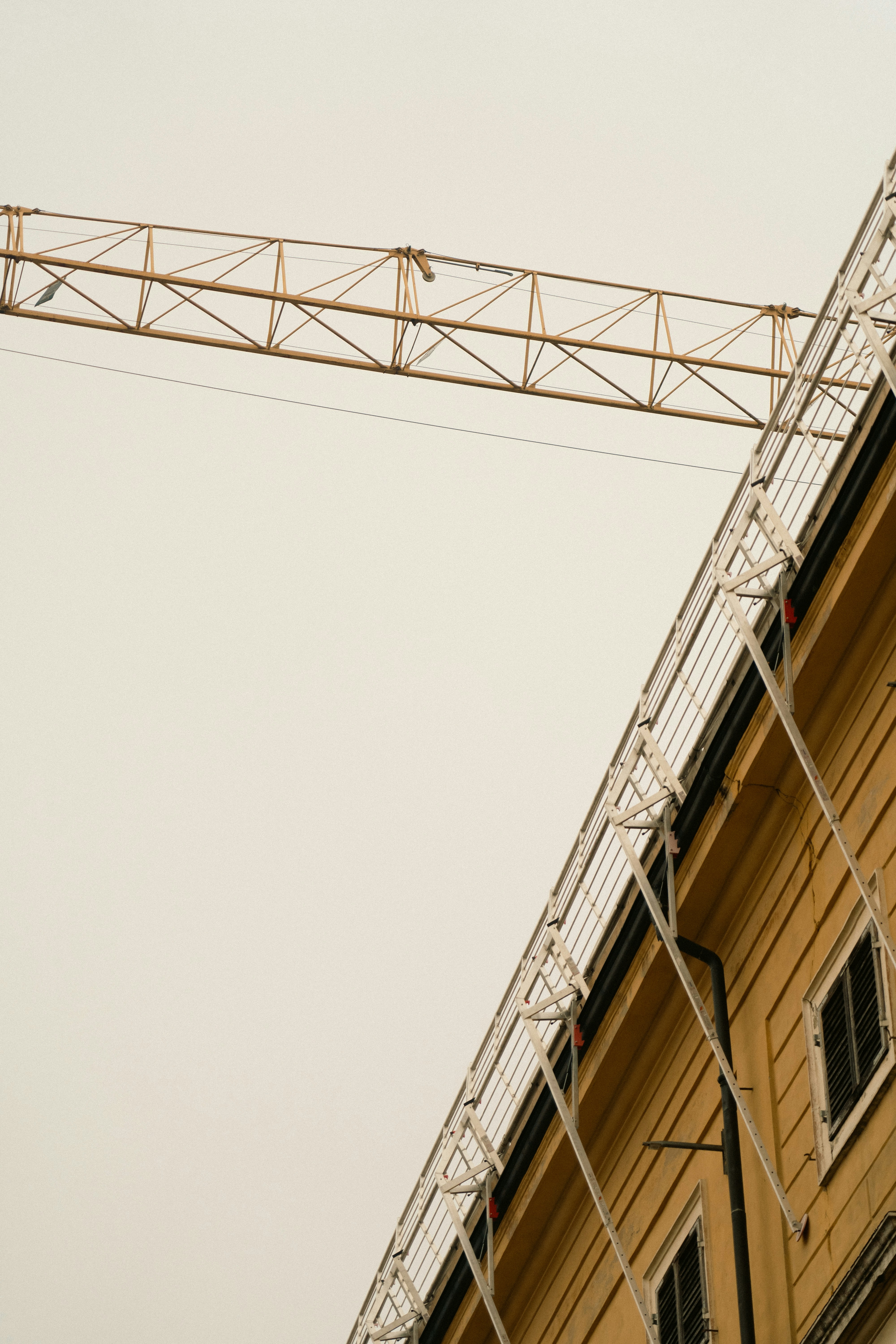 Horizontal Crane Across a Sunlit Facade: Geometry in Yellow Architecture