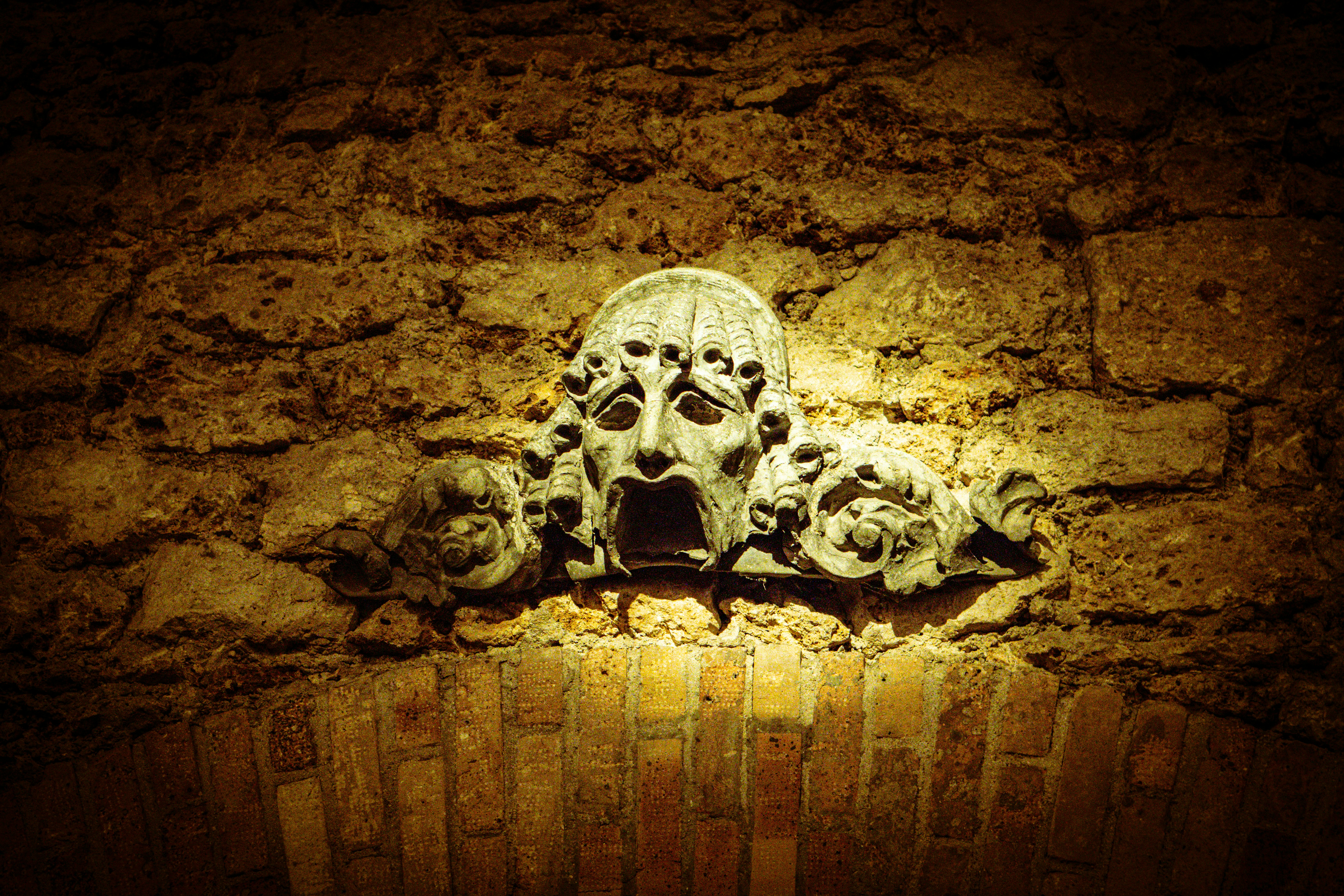 Gargoyle in Warm Gloom: A Stone Sentinel Over Brickwork
