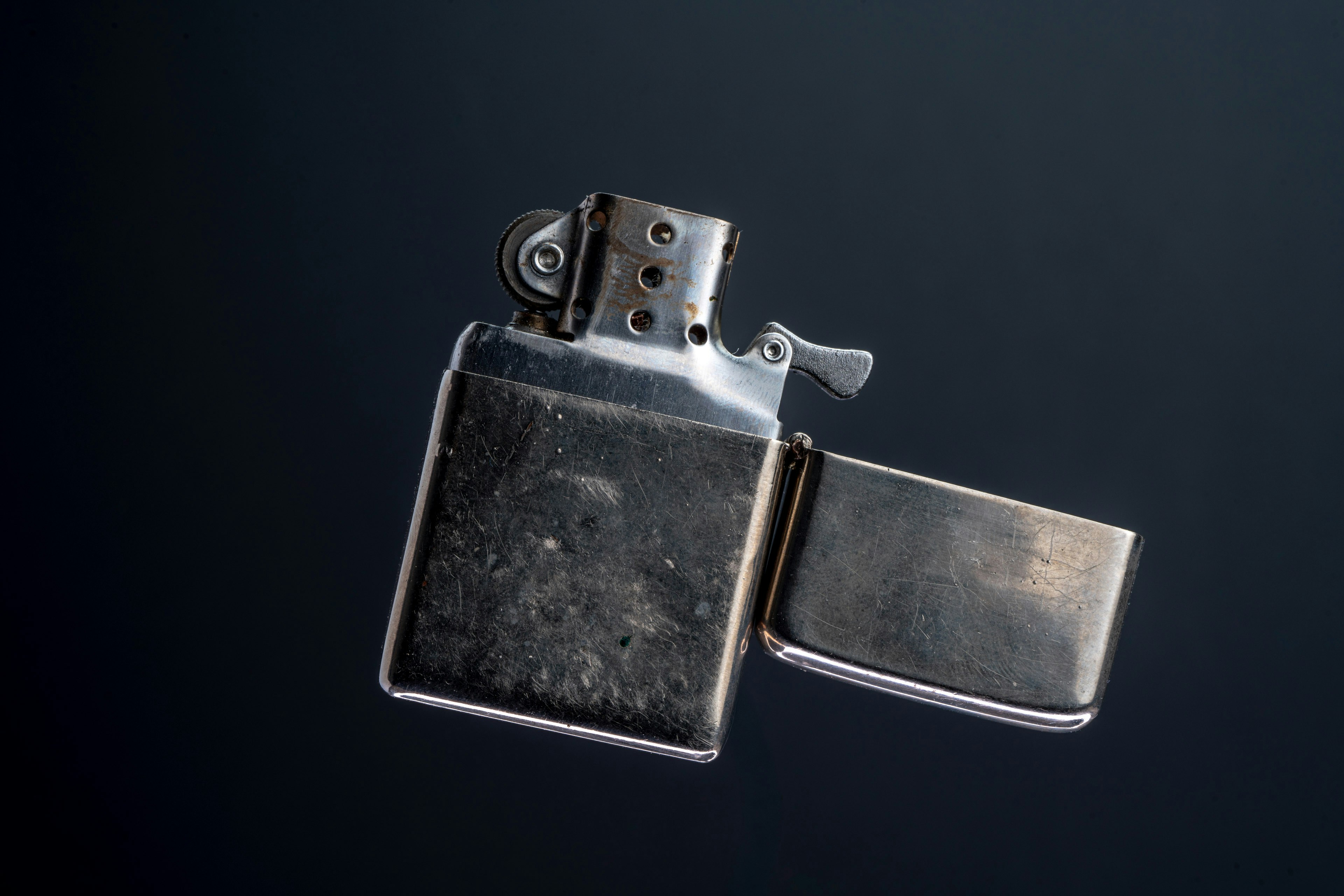 A lighter is shown in the air with a black background photo – Free ...