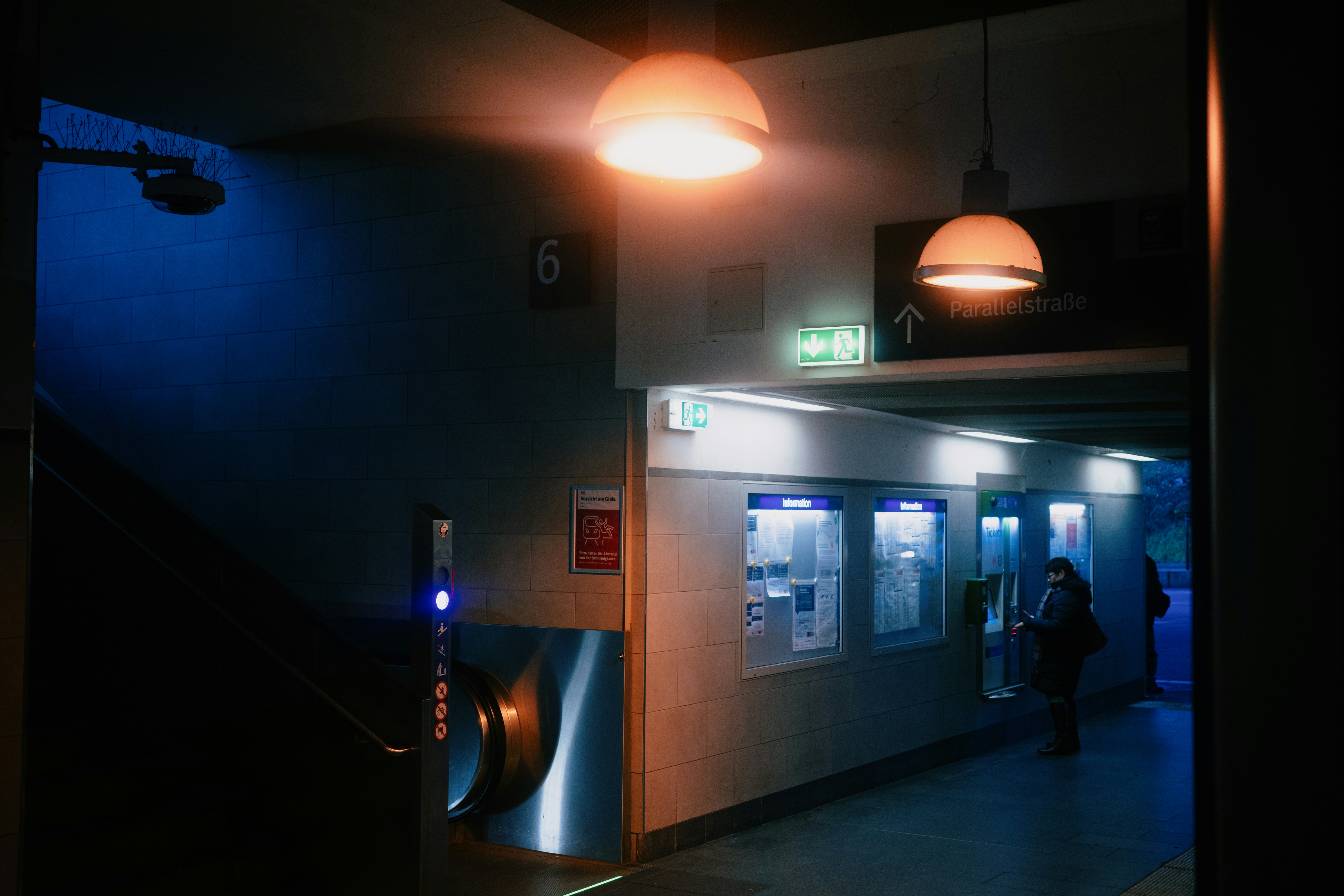 A hallway in a building with a blue light photo – Free Building Image ...