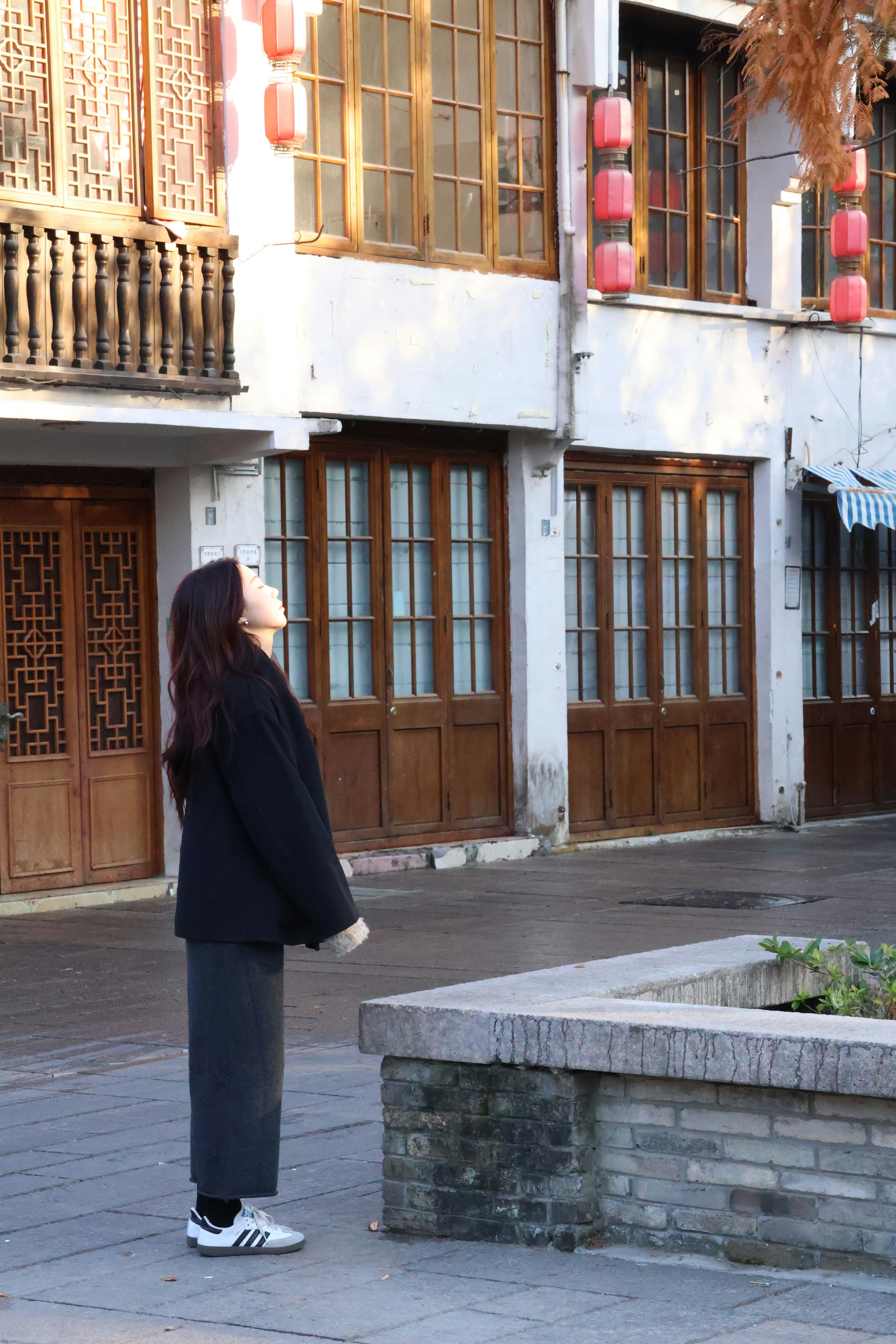 Gazing Upward Under Lanterns: A Quiet Street Portrait
