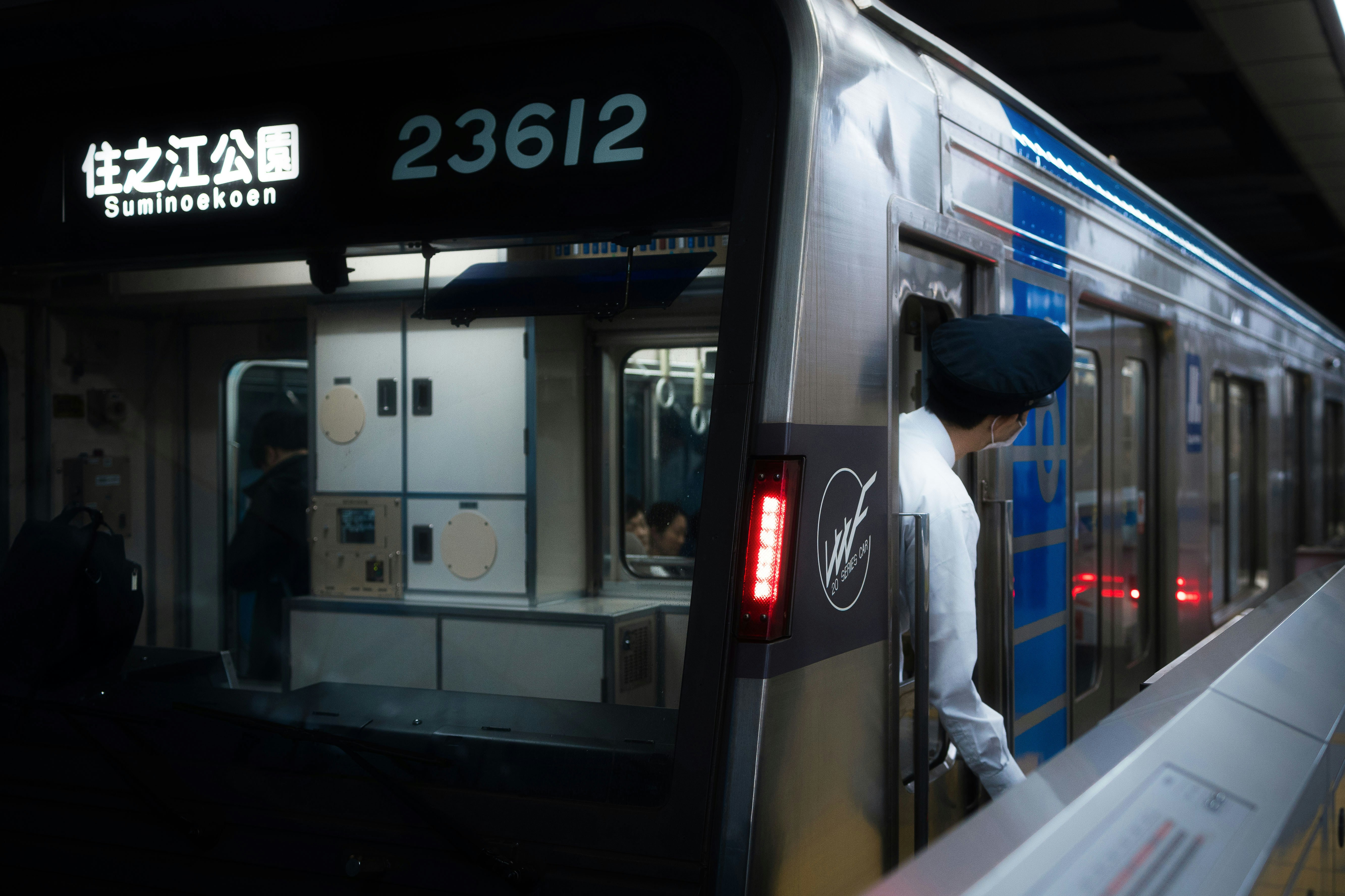A man standing on a platform next to a train photo – Free Osaka Image ...